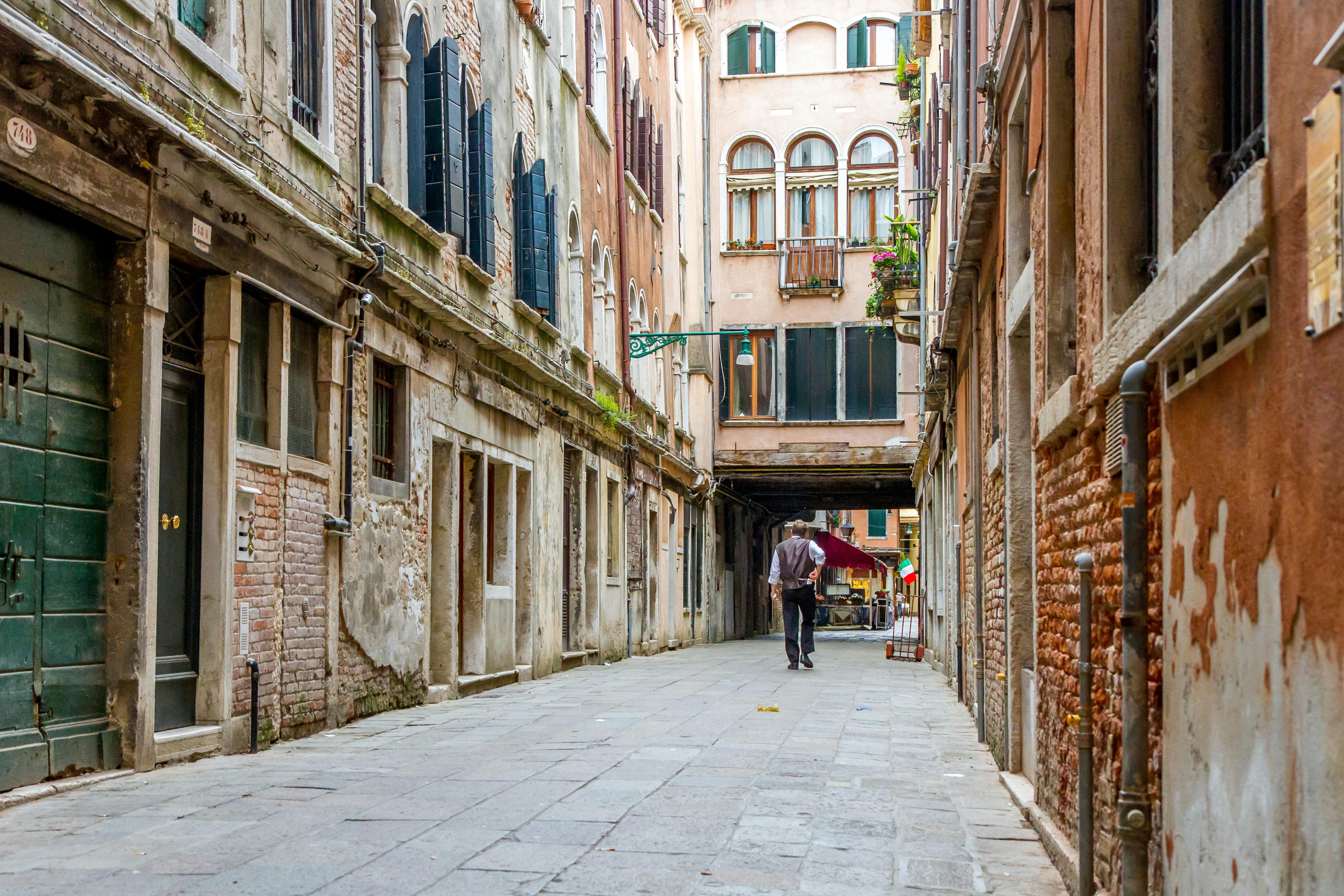 Waiter walking in a small alley in Venice, Italy
