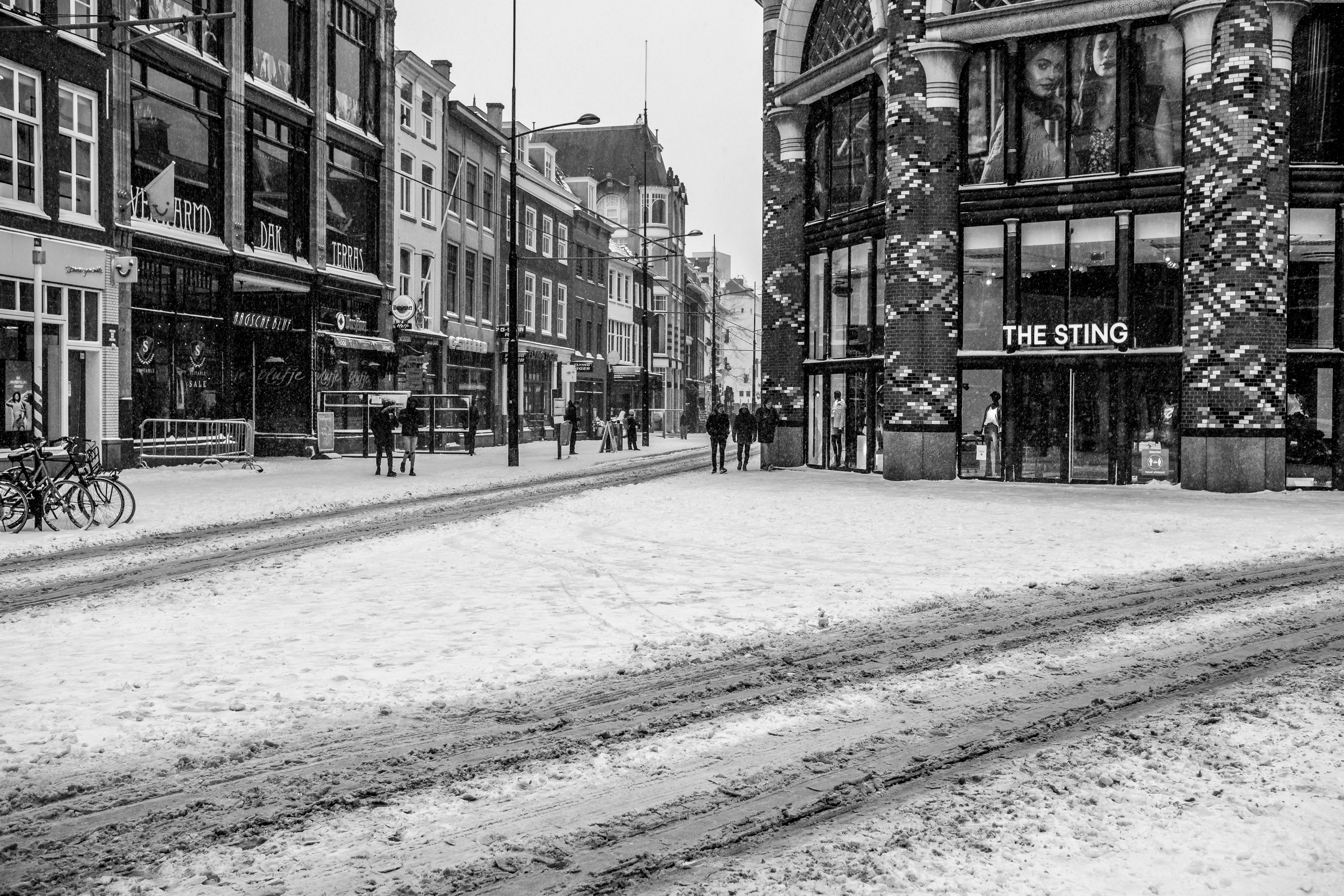 Snow-covered street in The Hague city center with historic buildings lining the road.