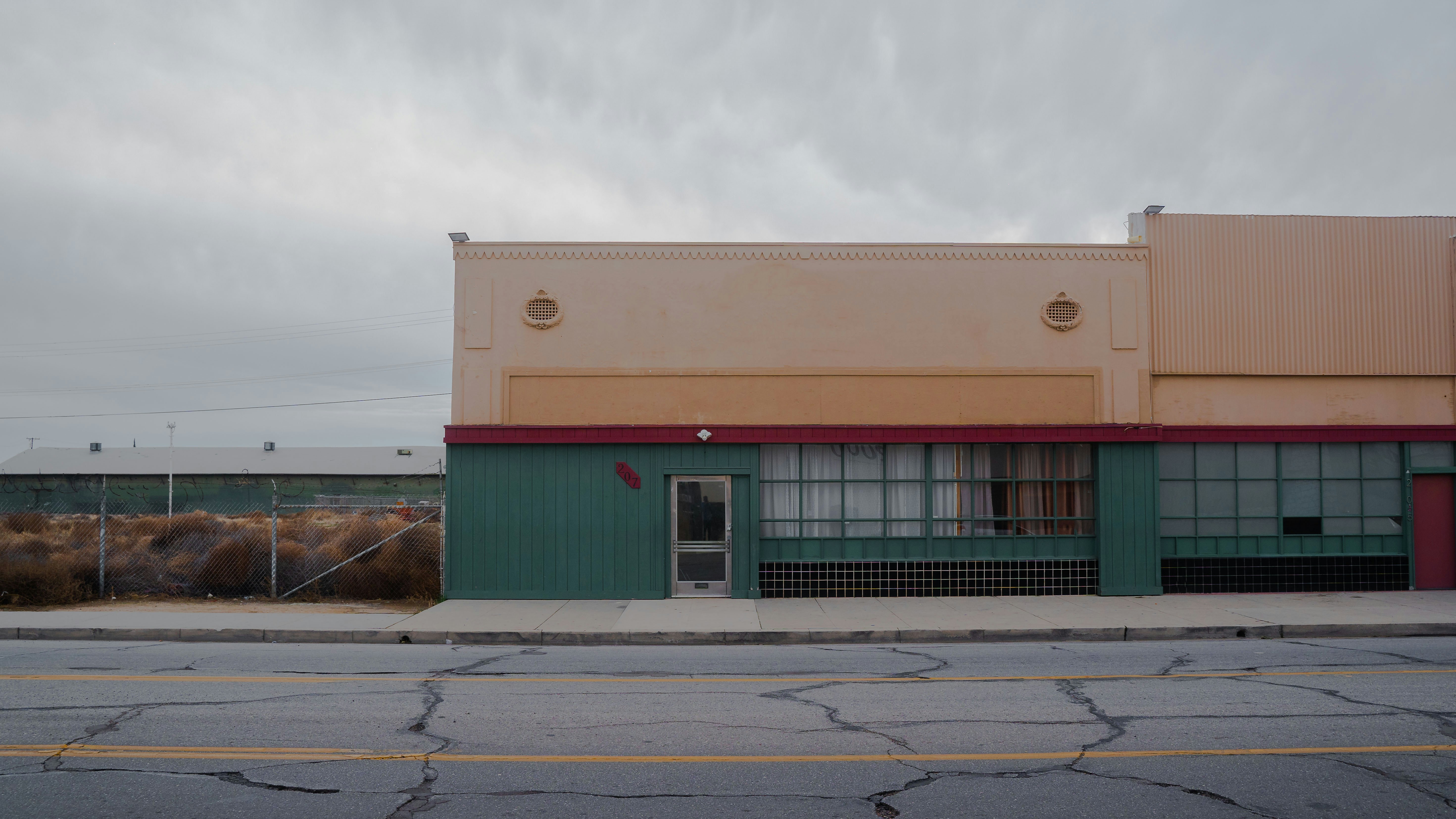 Pink and green building facade under an overcast sky.