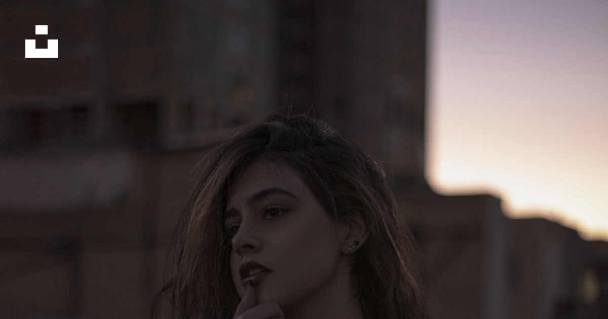 검은 블레이저를 입은 여자가 밤 시간 동안 보도에 앉아 있다 사진 Unsplash의 무료 초상 이미지