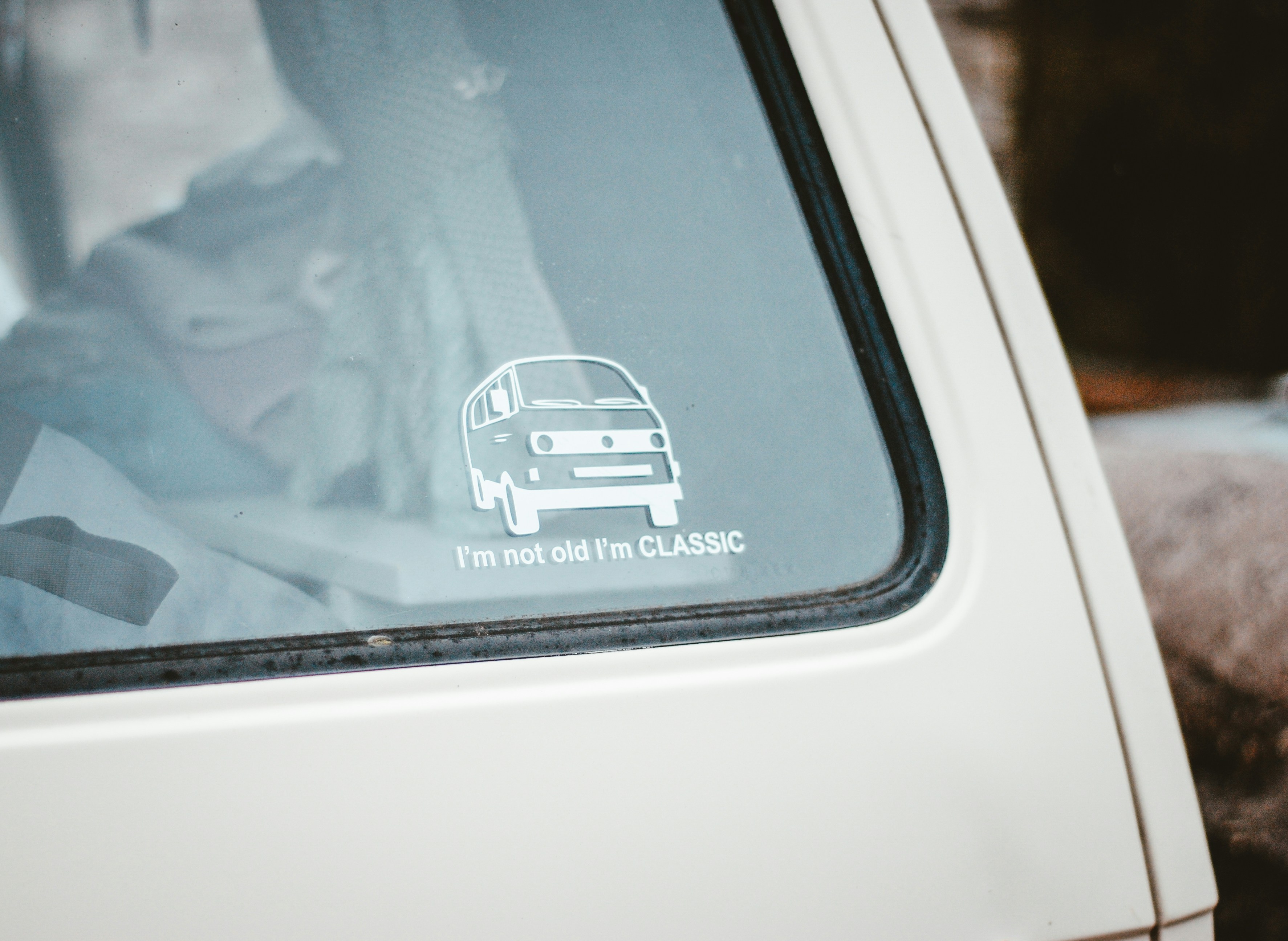I'm not old, I'm CLASSIC: A Tiny Retro Van Sticker on a White Car Window