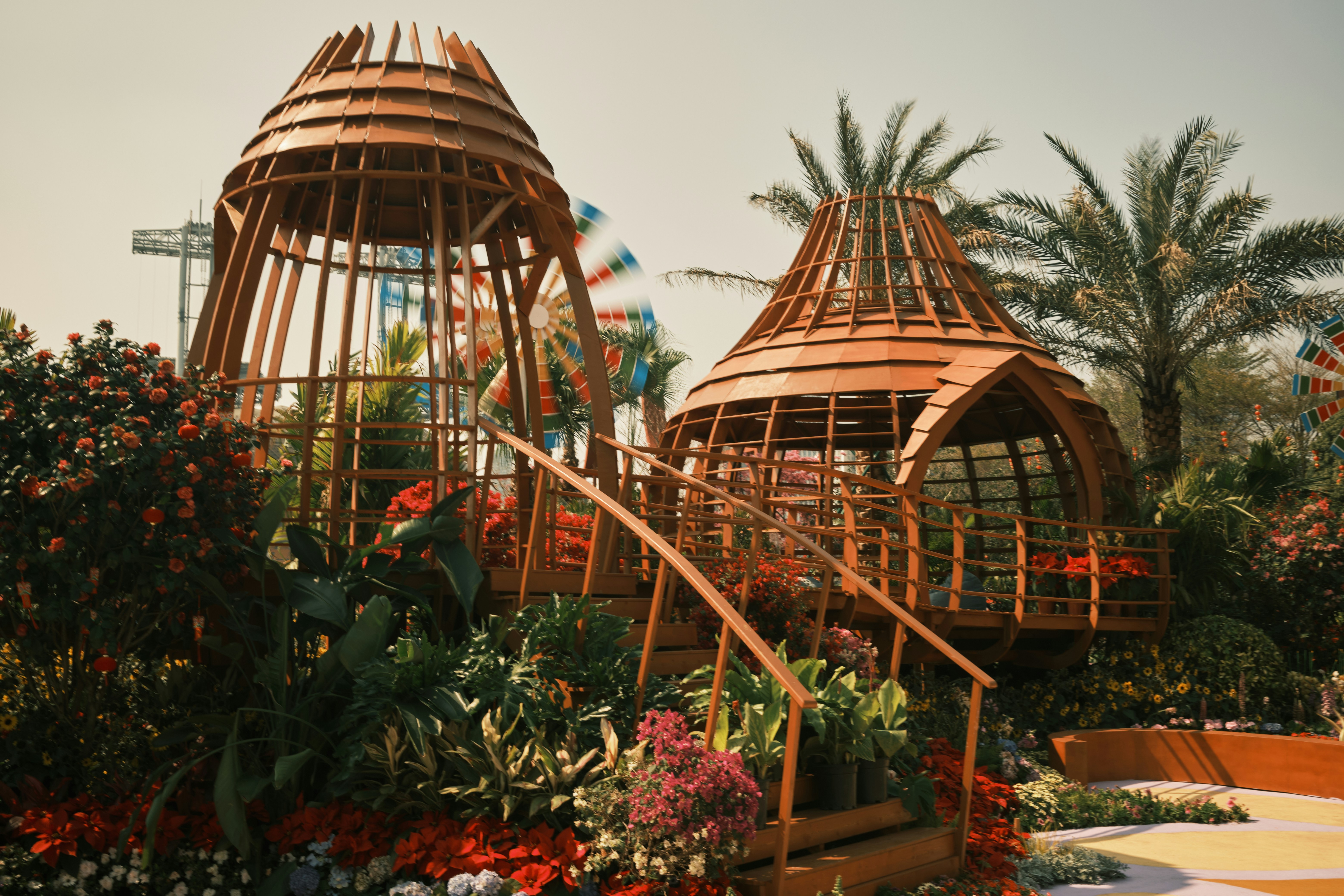 Wooden domes among tropical blooms at a sunlit garden pavilion