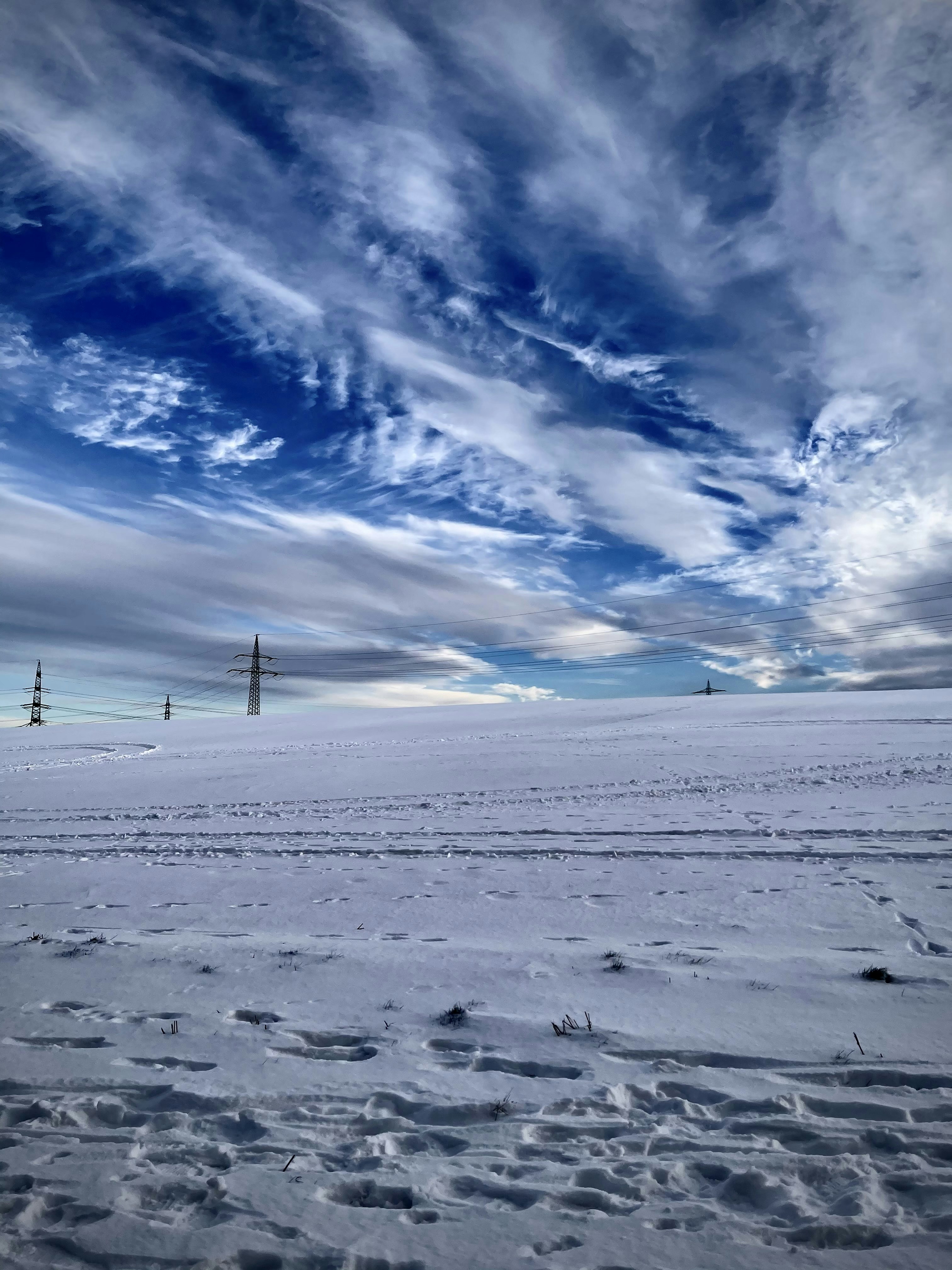 Snowfield Under Expansive Sky with Power Lines