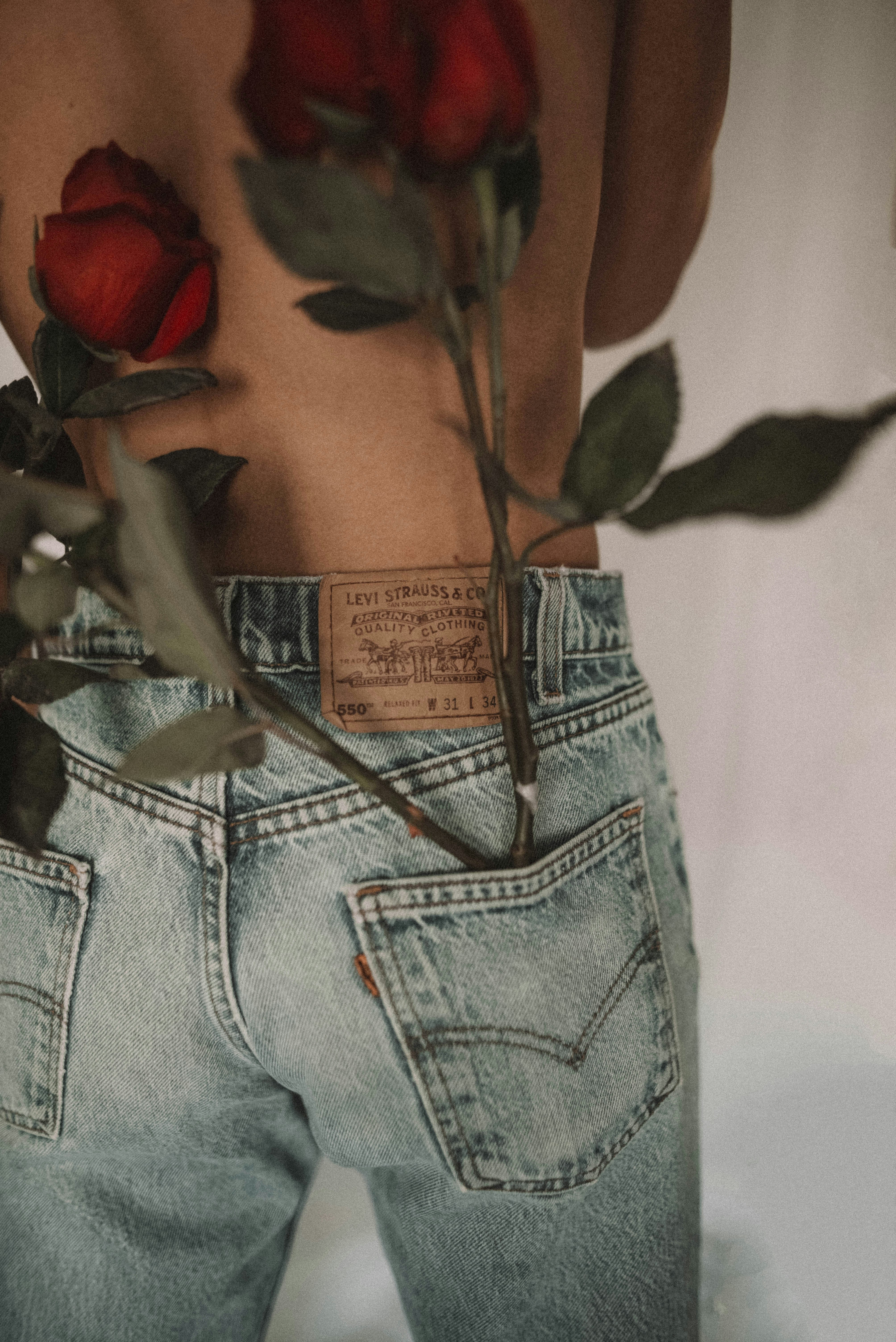 blue denim jeans on brown and beige floral textile