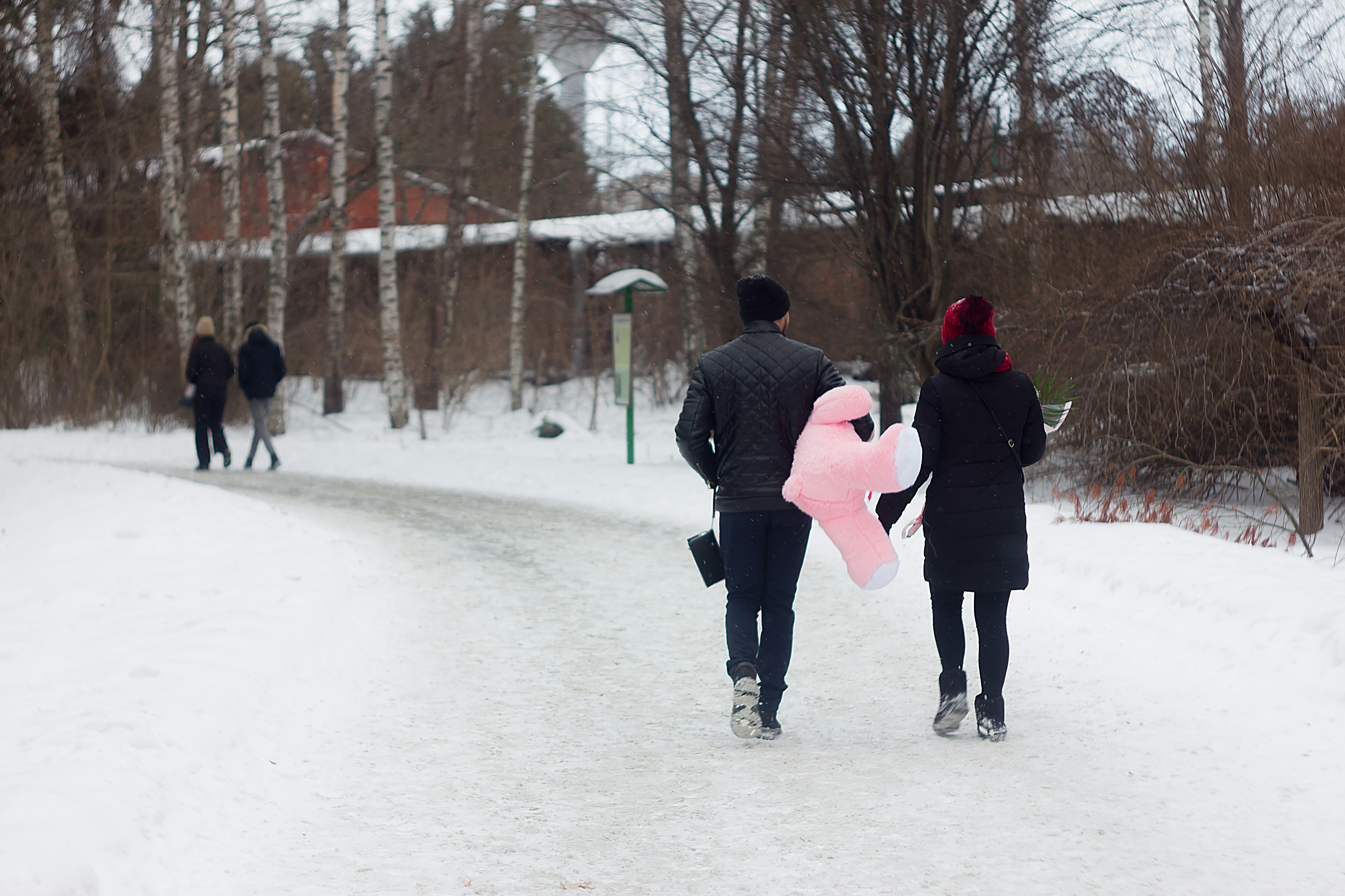 man in black jacket holding girl in pink jacket during daytime