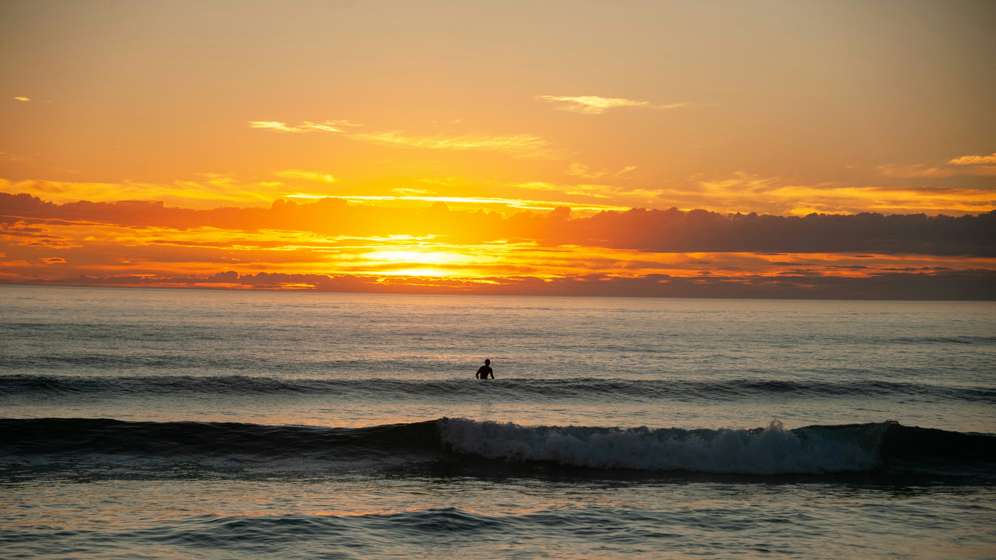 Foto Persona surfeando en el mar durante la puesta de sol – Imagen ...