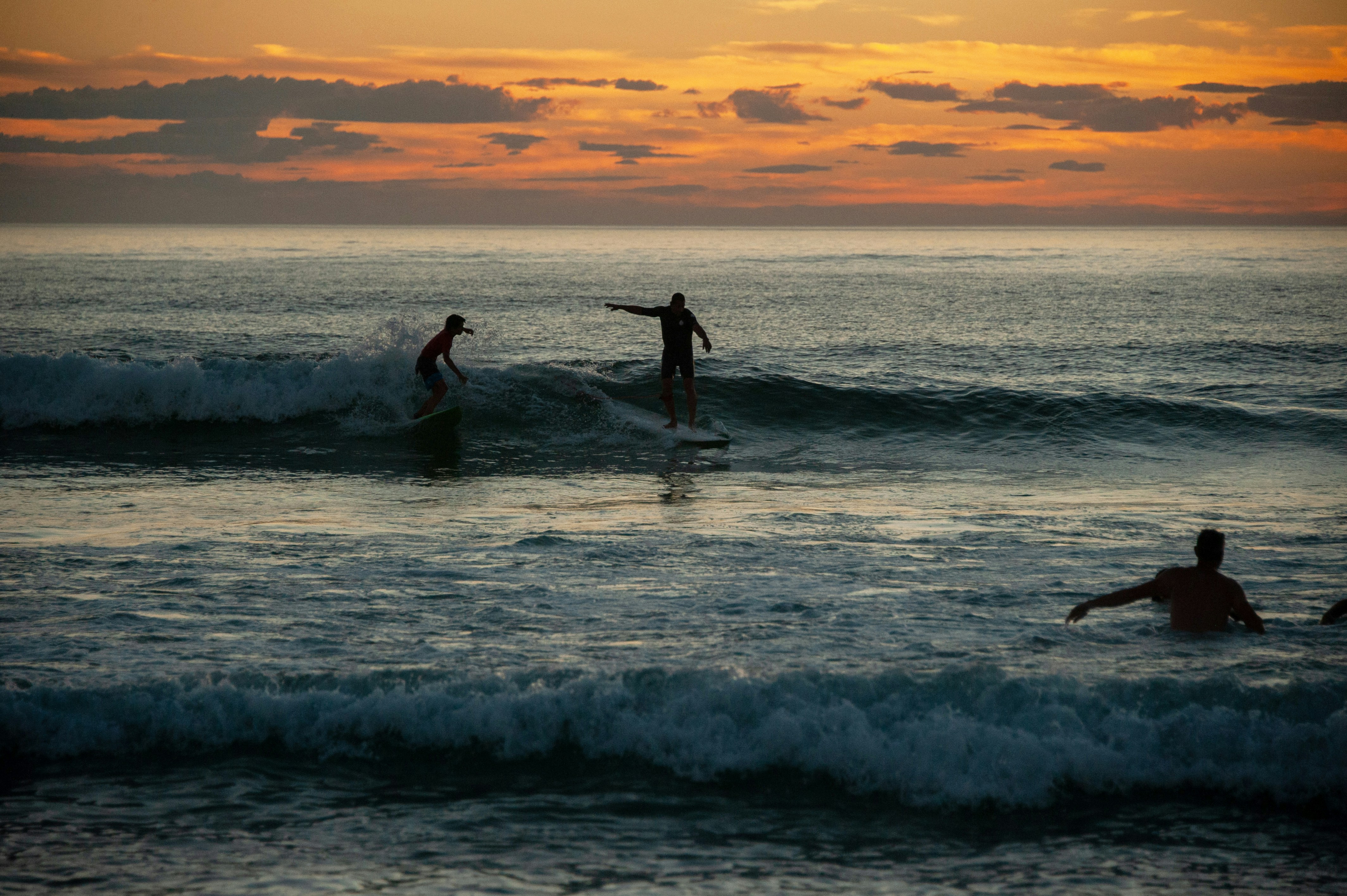Foto 2 personas surfeando sobre las olas del mar durante la puesta de sol – Imagen Seignosse ...
