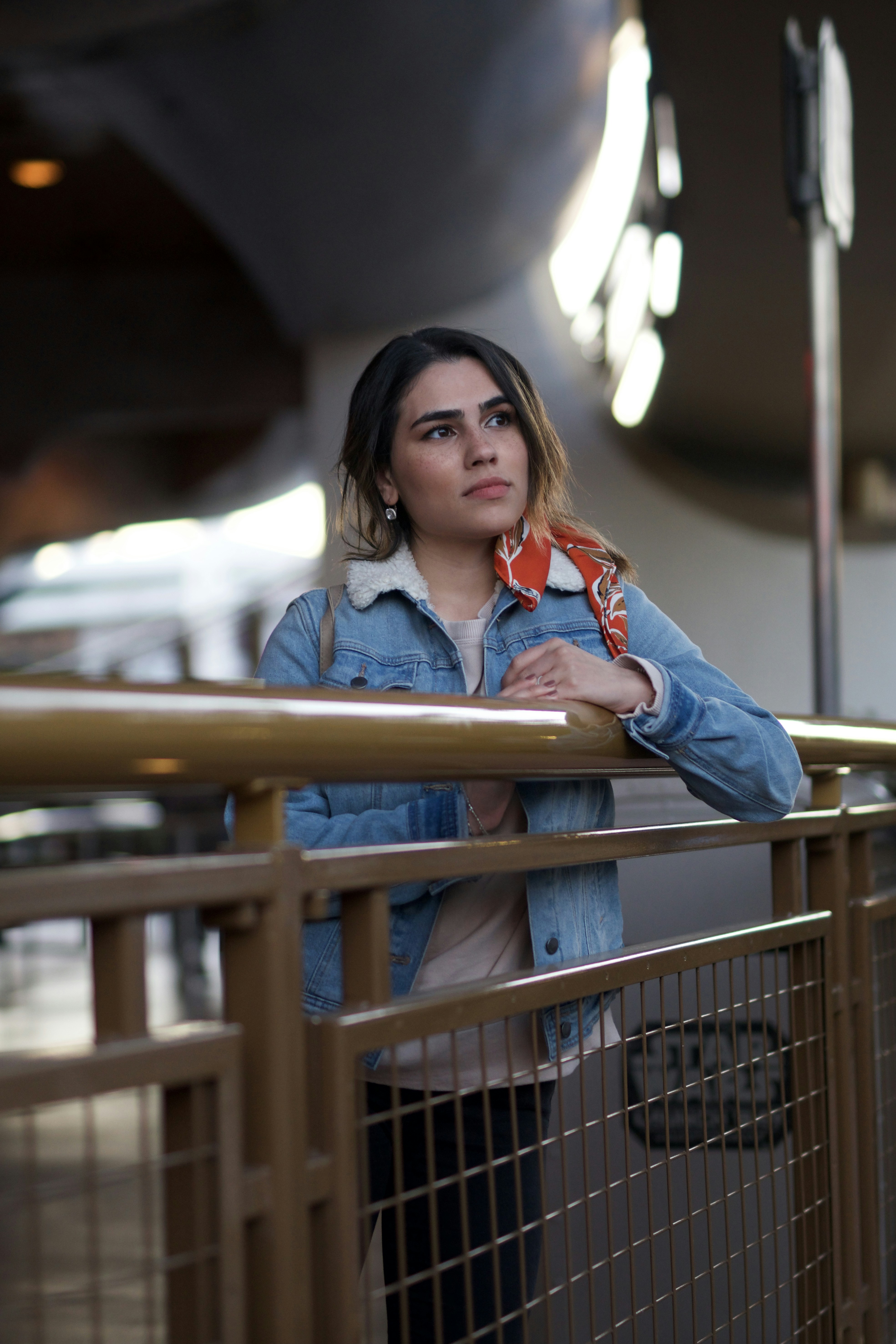Denim Gaze on a Golden Railing: A Quiet Portrait in Transit Light