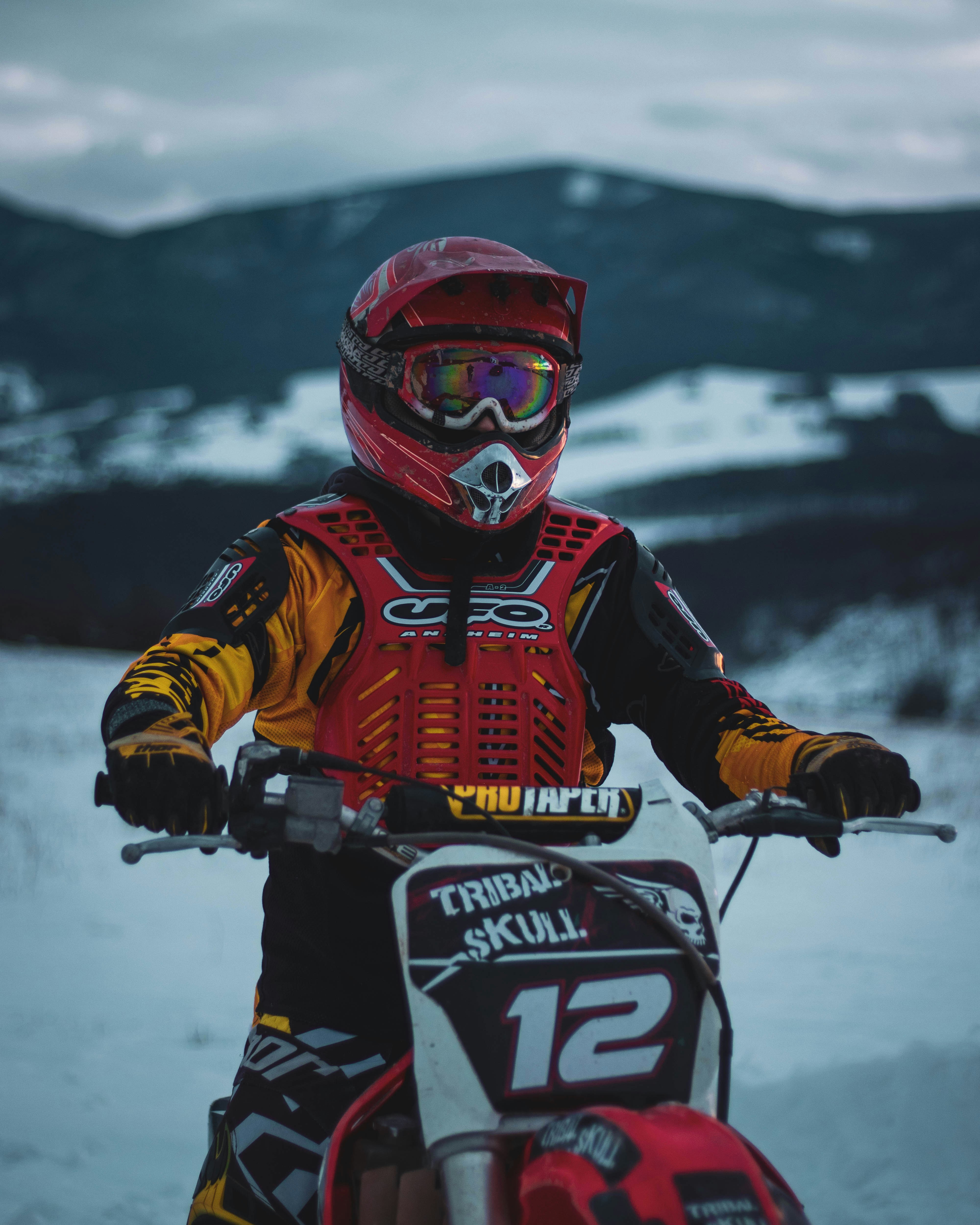 Helmeted rider on a snow-dusted track, number 12, facing forward