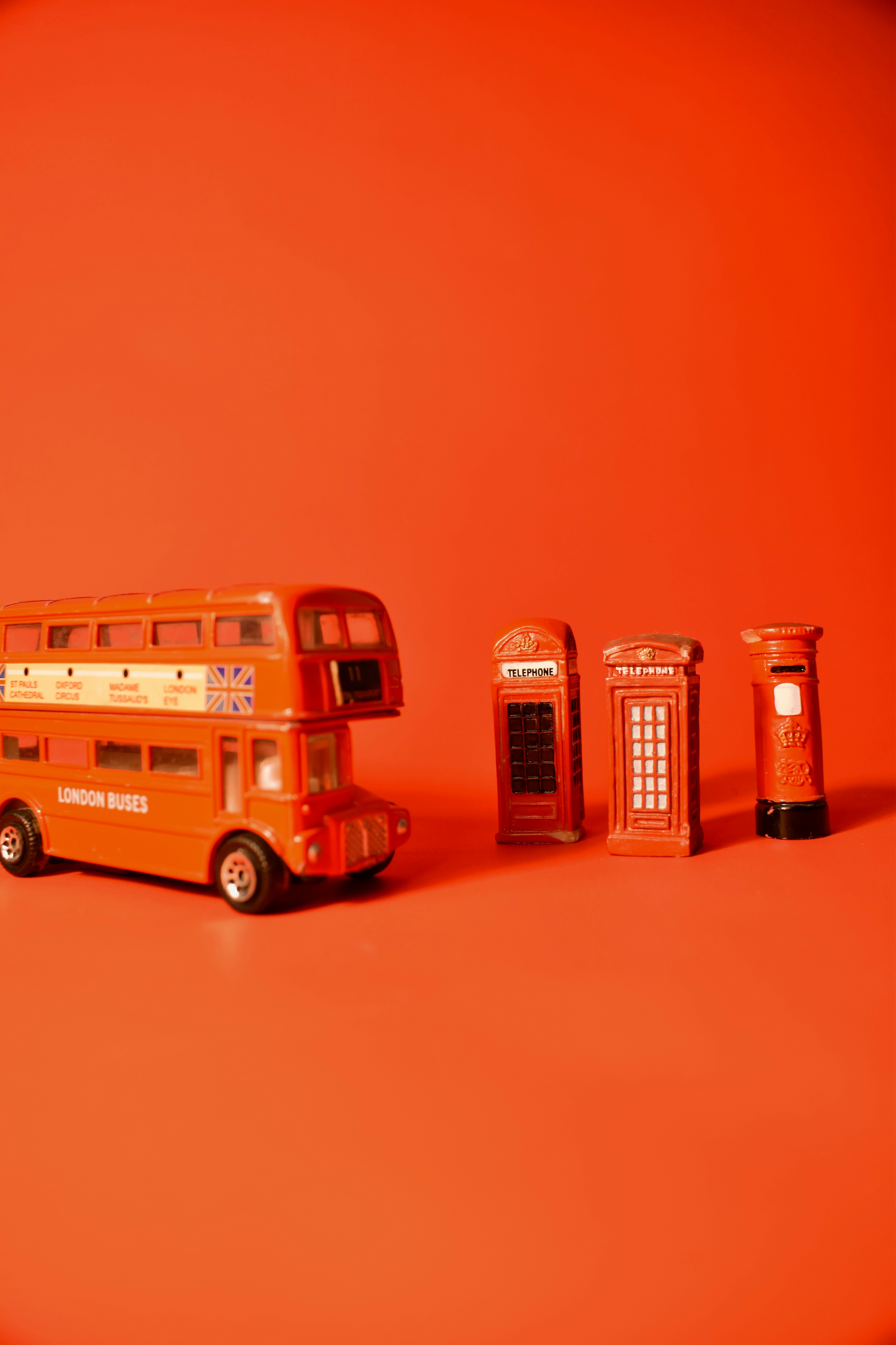 Crimson Miniature: A London Bus and Red Post Boxes on a Scarlet Stage