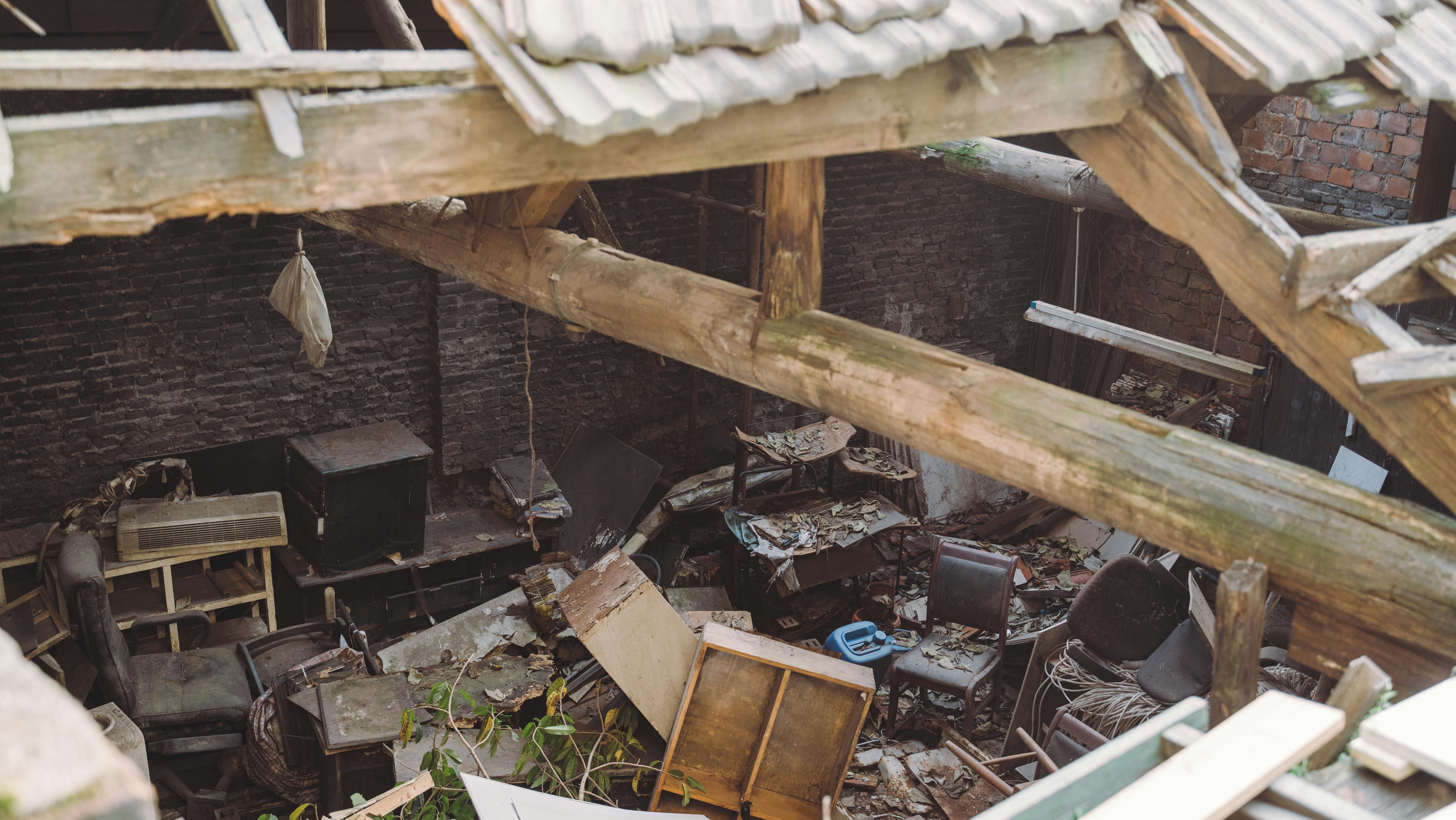 Ruinous Roofscape: Jumbled Furnishings Beneath a Timber Skeleton