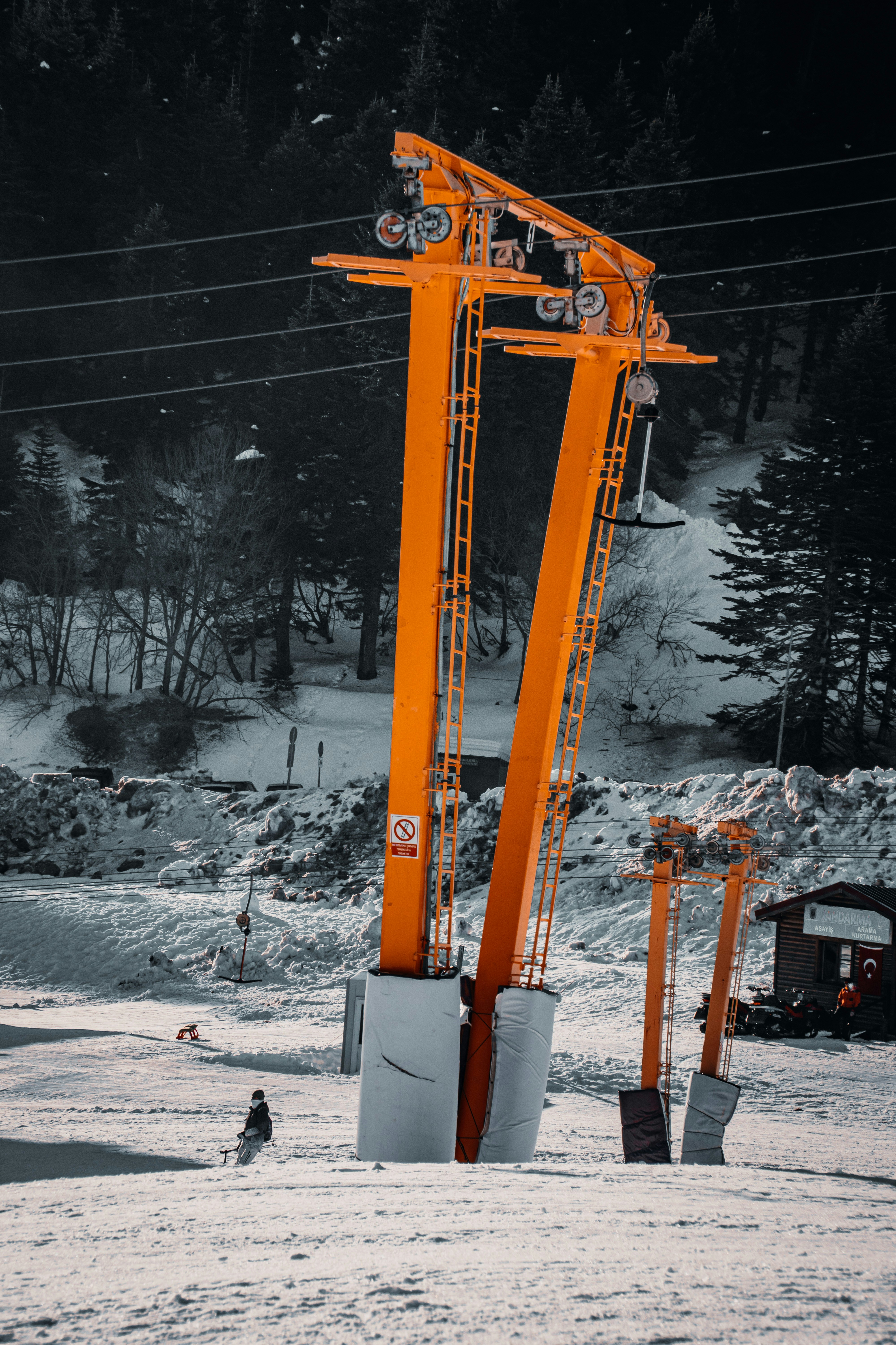 Orange Steel Leviathan: a Ski Lift Tower Dominates a Snowy Slope