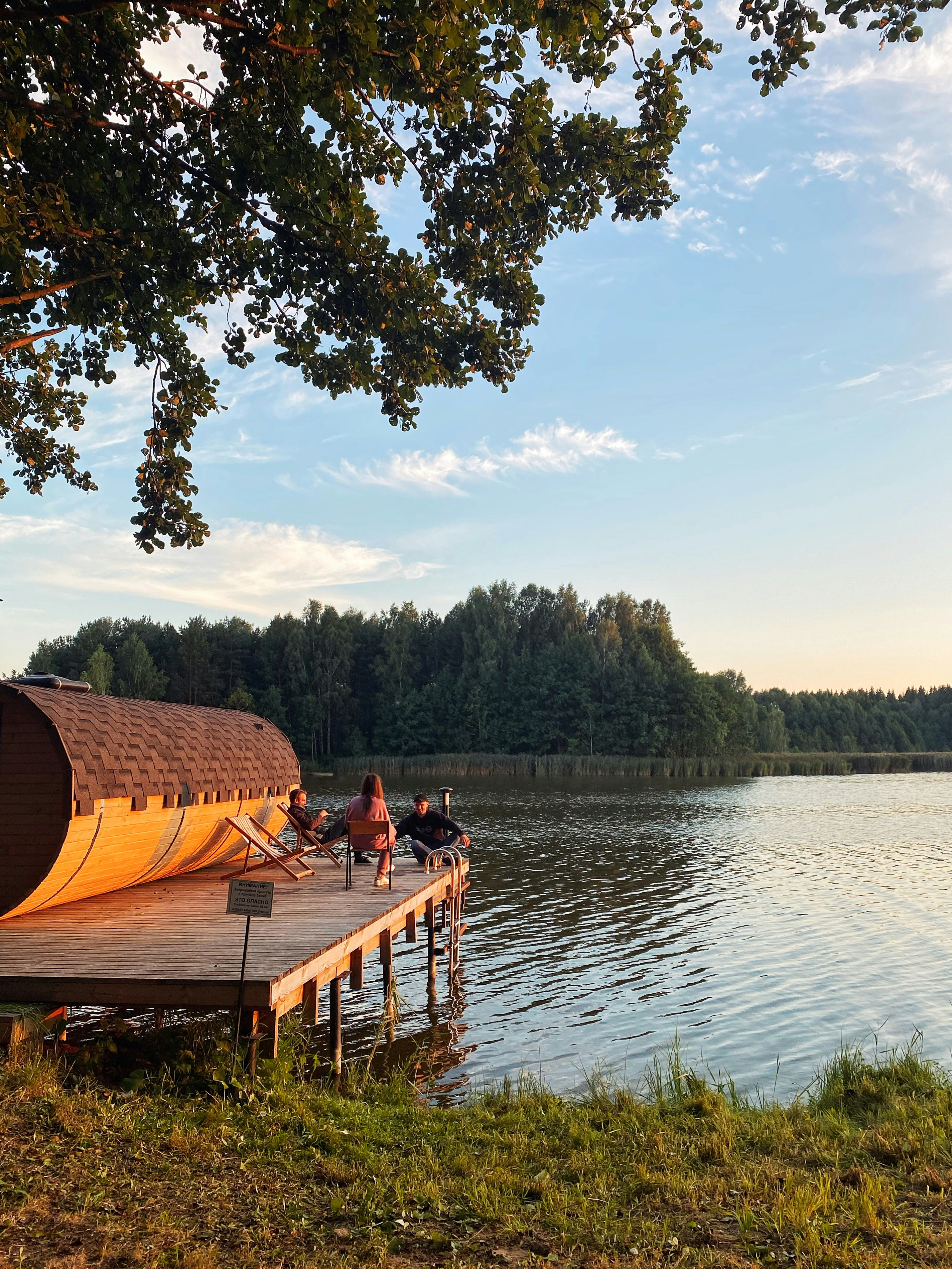Sunlit Boathouse Terrace: Friends at Dusk by the Lake