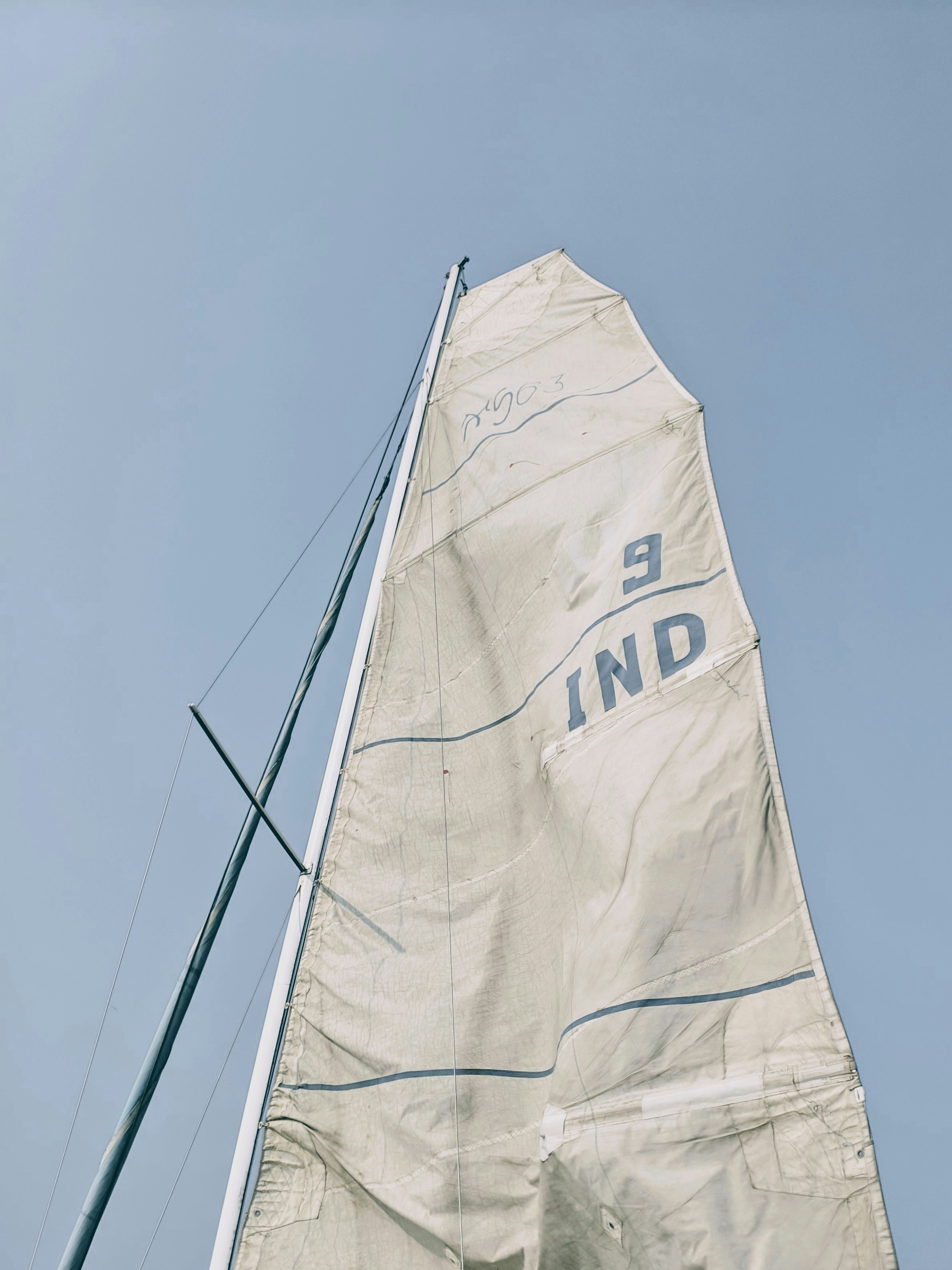 Weathered Sail Against a Pristine Sky: Diagonals and Rigging in Focus