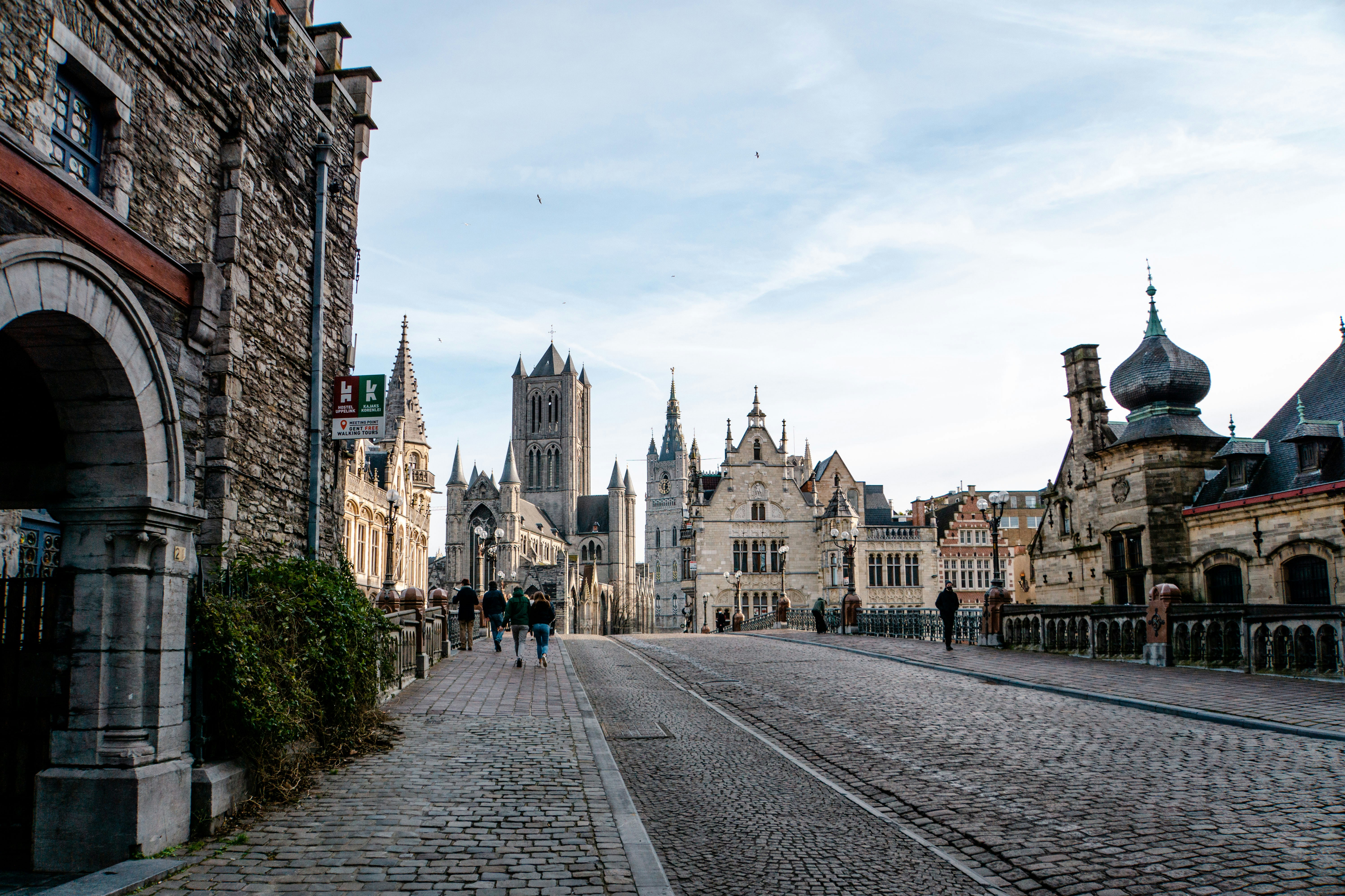 Historic European street lined with ornate buildings under a clear blue sky.