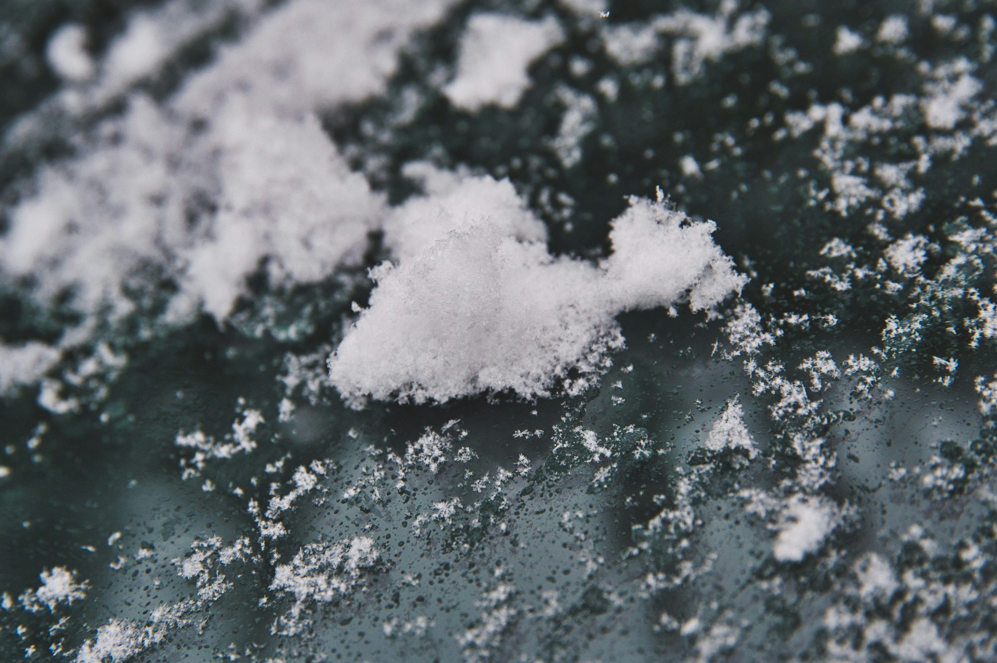 Delicate snowflakes rest on a dark surface, creating a serene contrast that captures the essence of winter's touch.