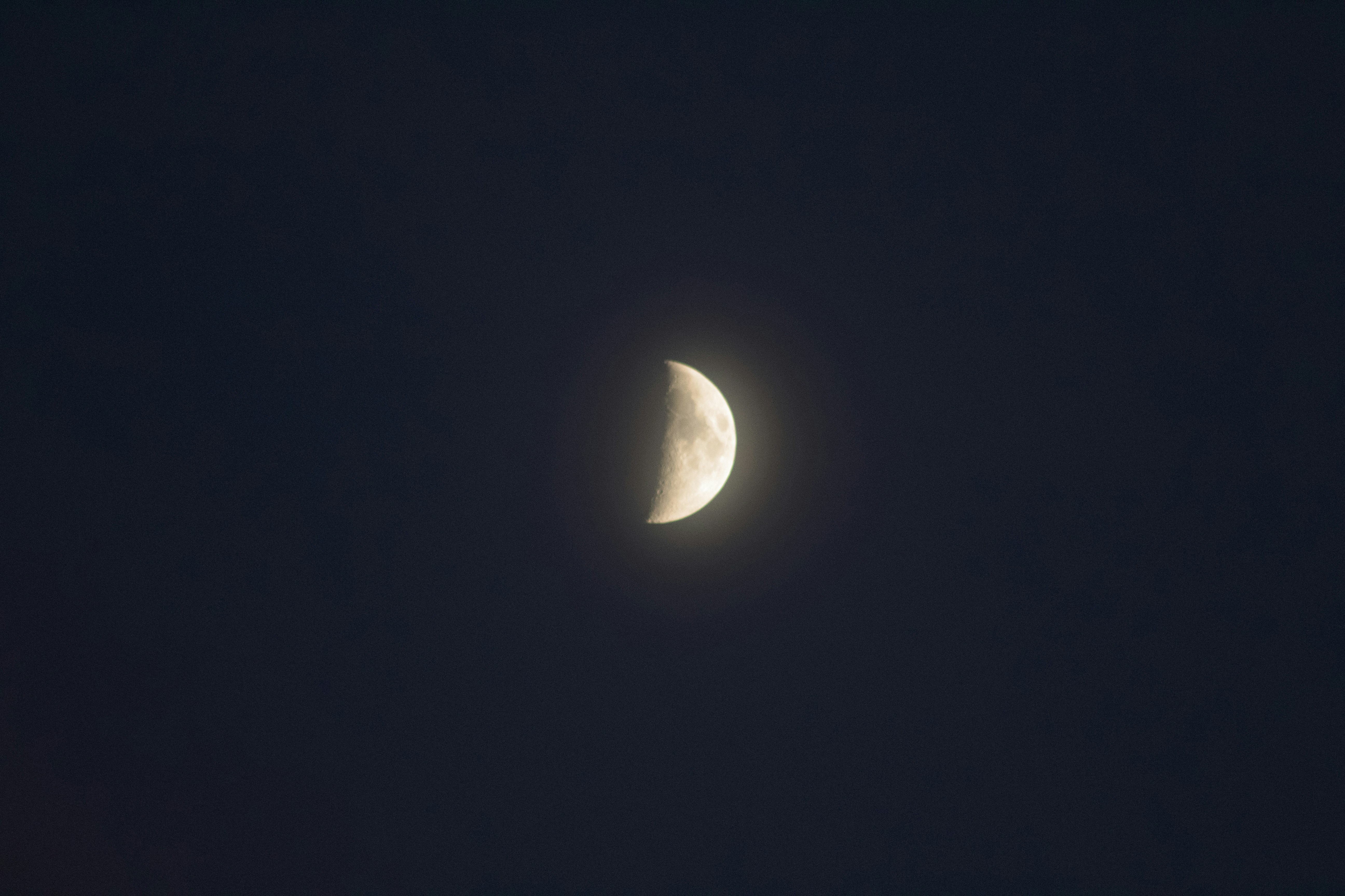 Waxing crescent moon against a deep blue night sky.