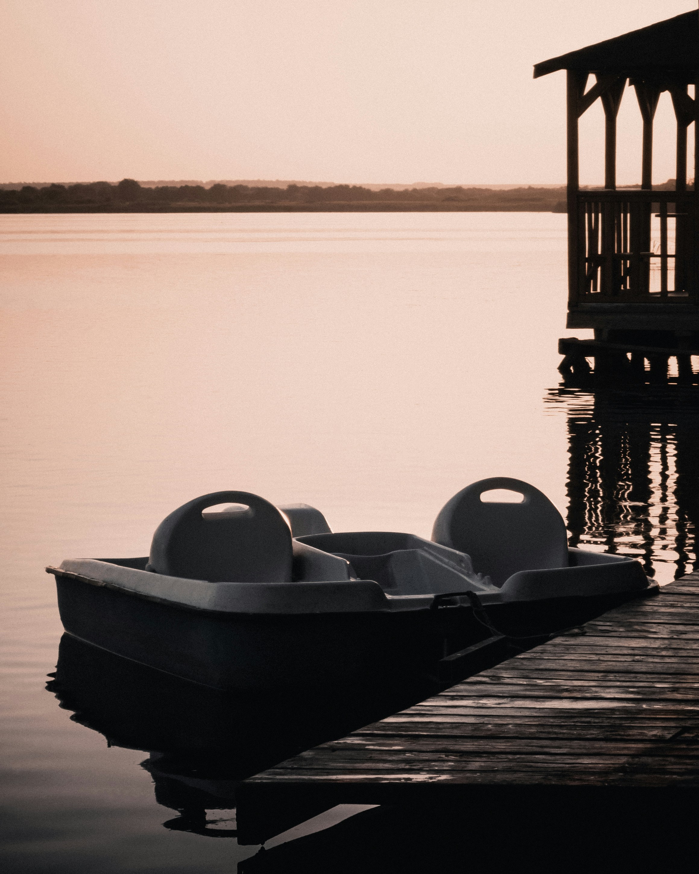 Twilight Quiet at the Dock: Pedal Boat Silhouette by Calming Water