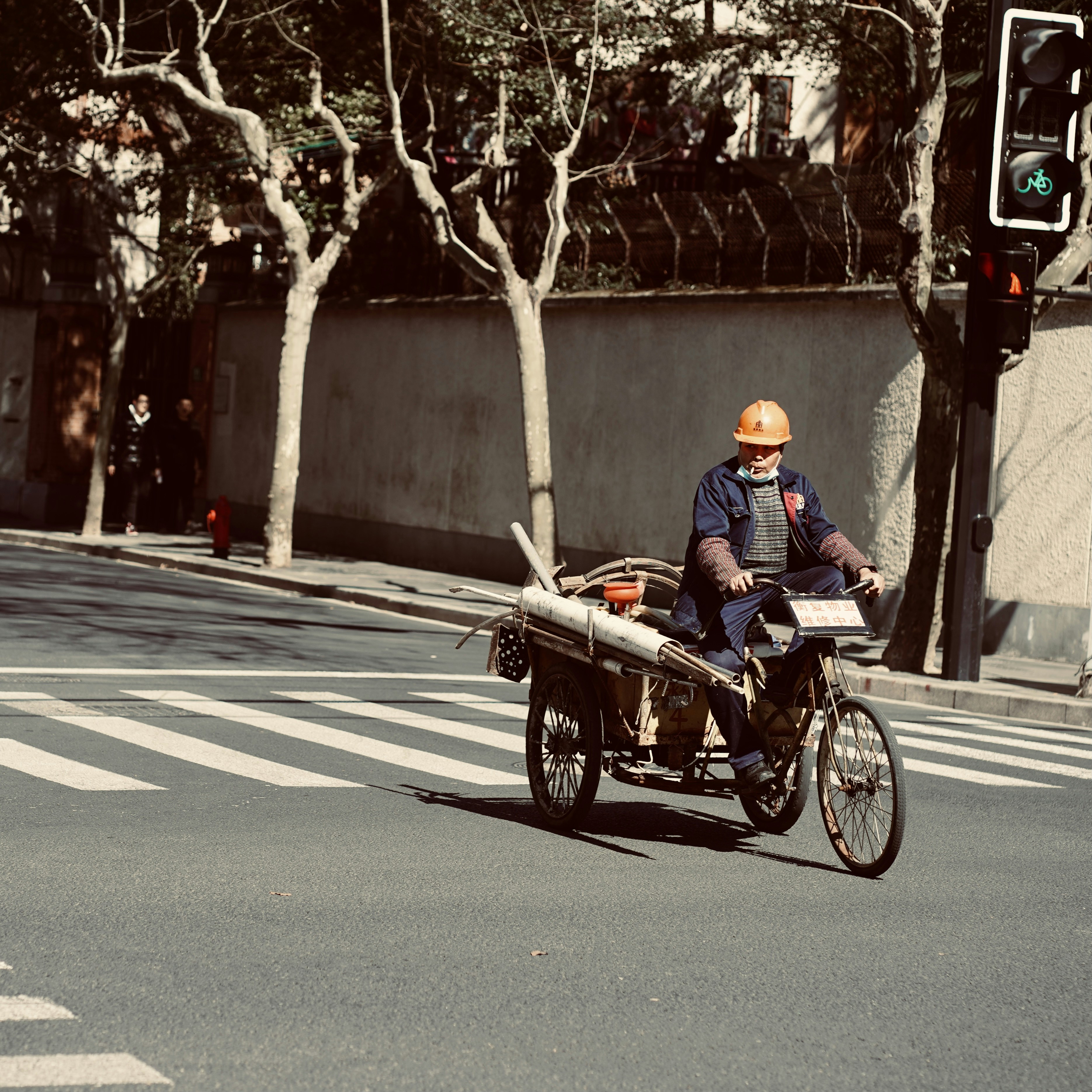 Orange Helmeted Cyclist on a Cargo Trike at a Quiet Crosswalk