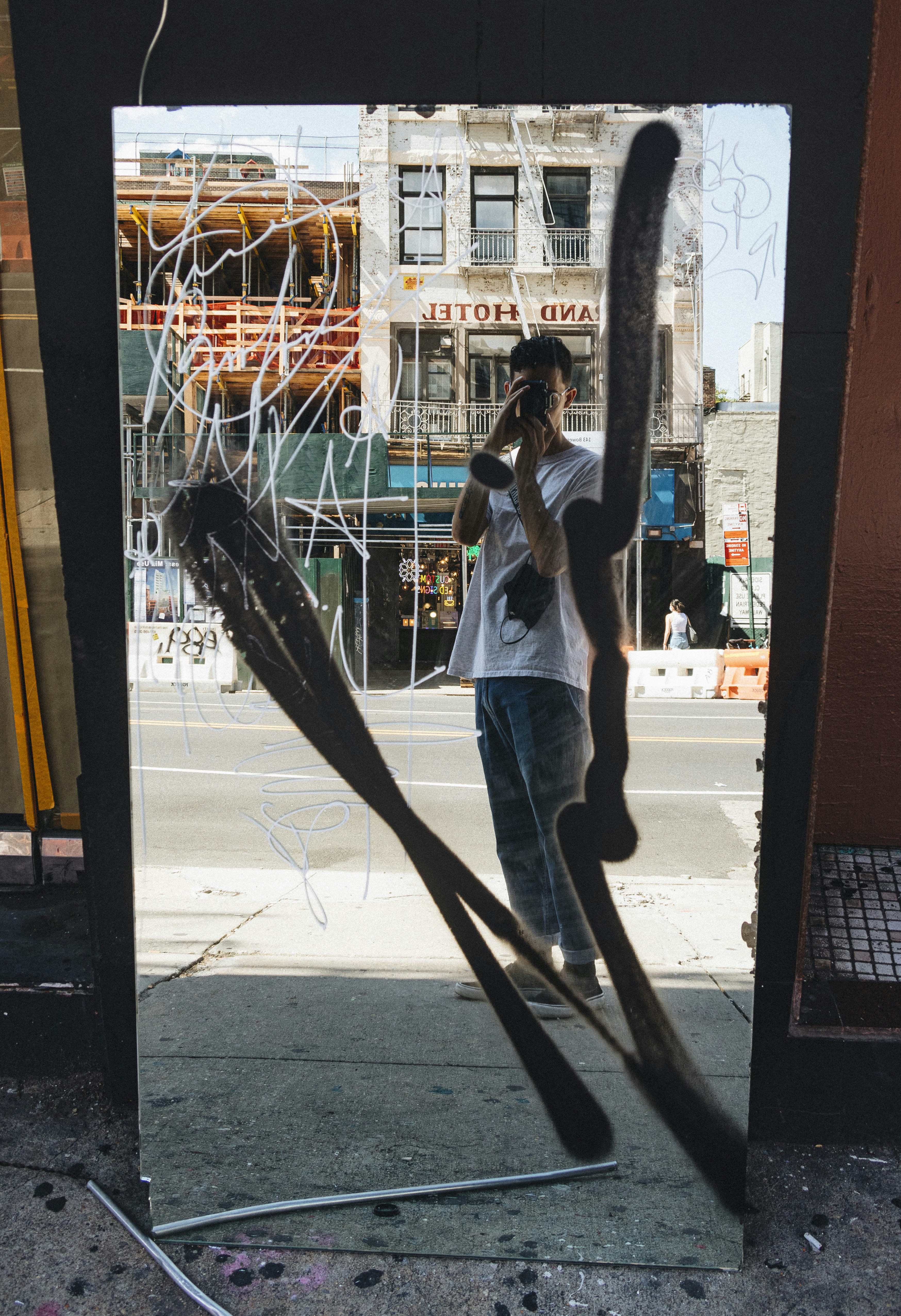 Through a Storefront Mirror: A Street Photographer's Reflection Amid Graffiti and City Noise