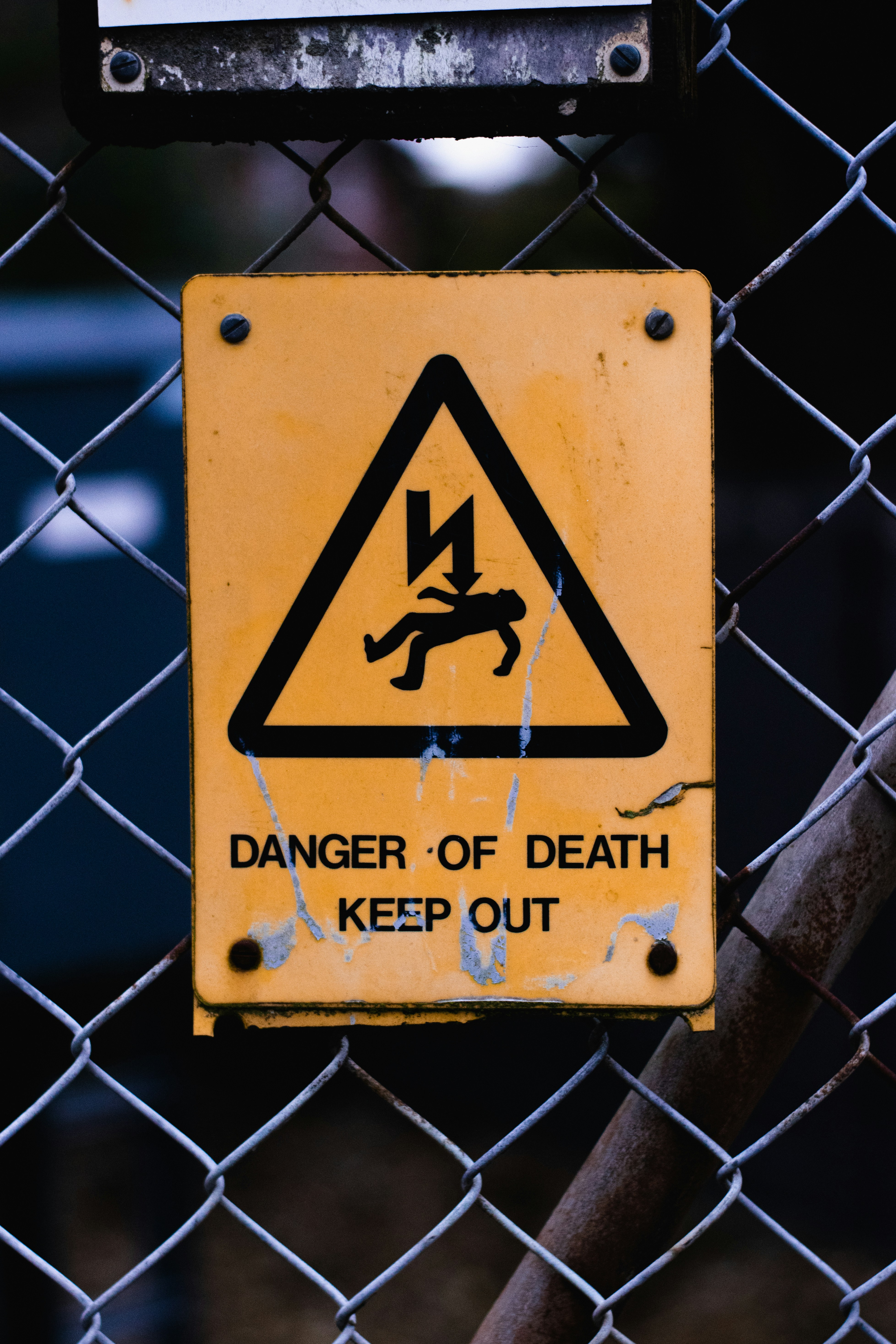 A warning sign on a chain link fence photo – Free Black Image on Unsplash