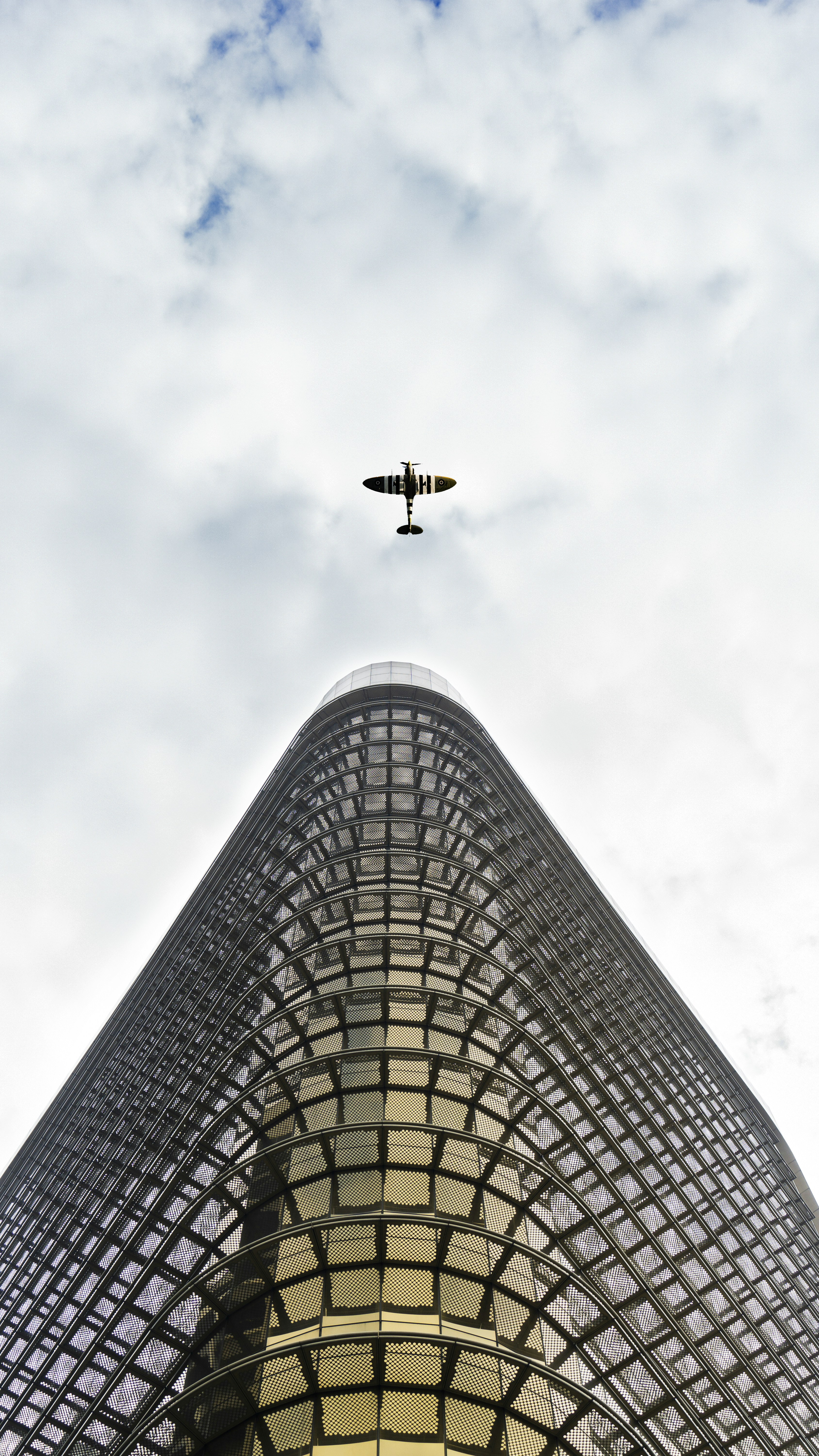 Plane Over the Glass Curve: An Upward View of a Tower