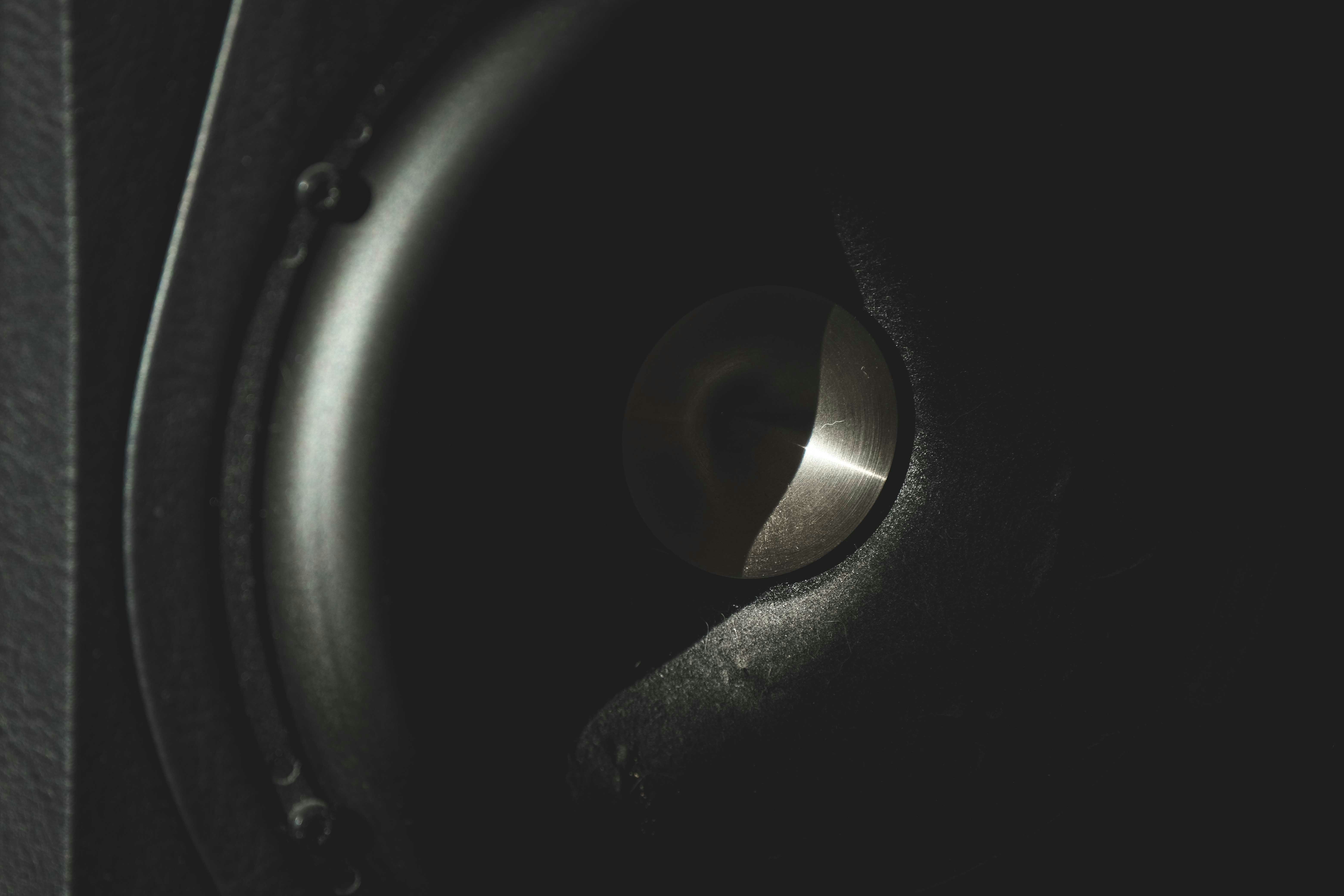 Close-up of a speaker cone with intricate details highlighting its texture and design. The image emphasizes the craftsmanship behind sound reproduction.