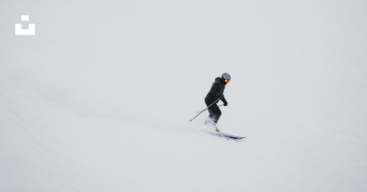 昼間、雪に覆われた地面でスキーブレードに乗る黒いジャケットと黒いズボンの男性の写真 Unsplashの楊の無料画像