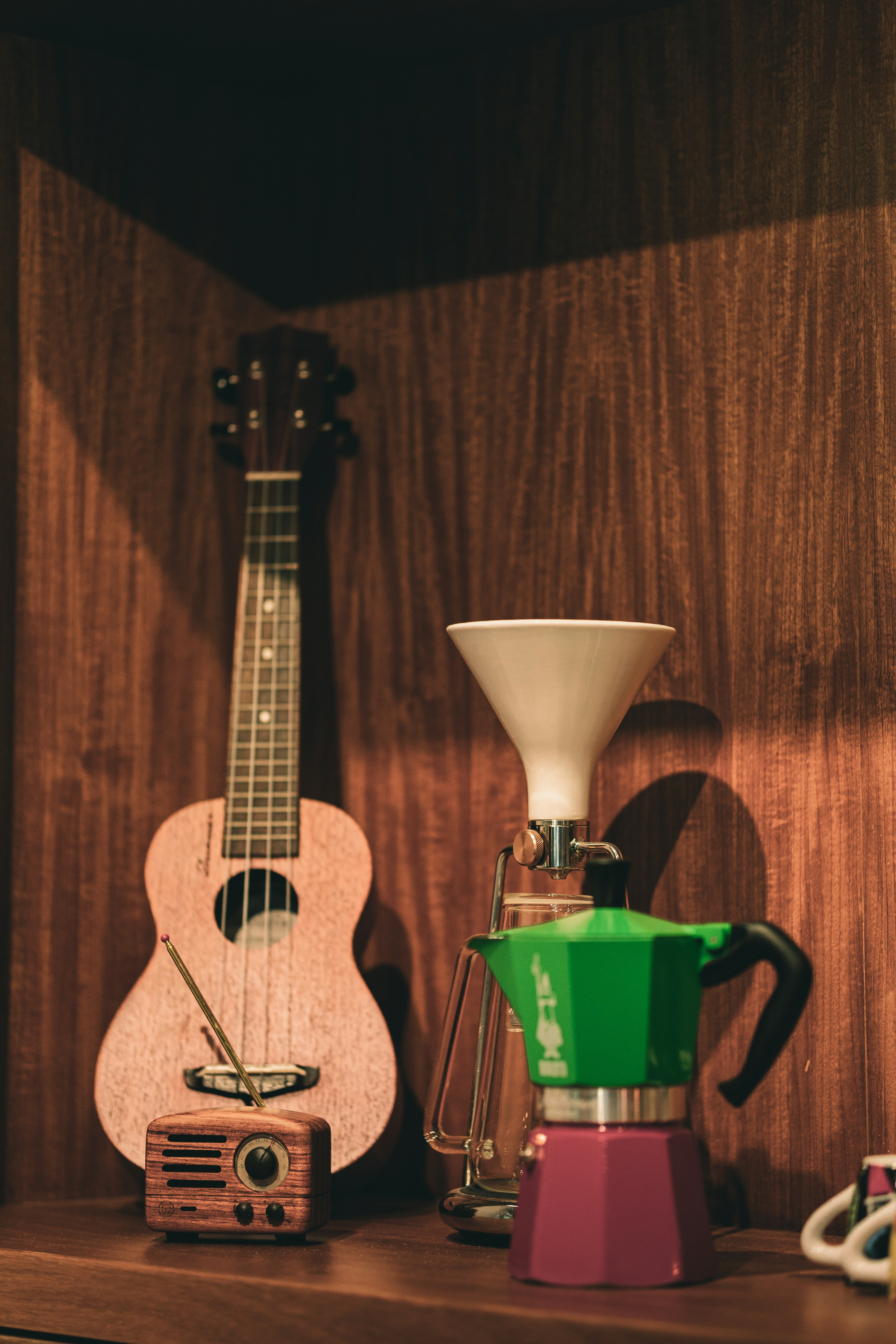 brown acoustic guitar beside green plastic cup