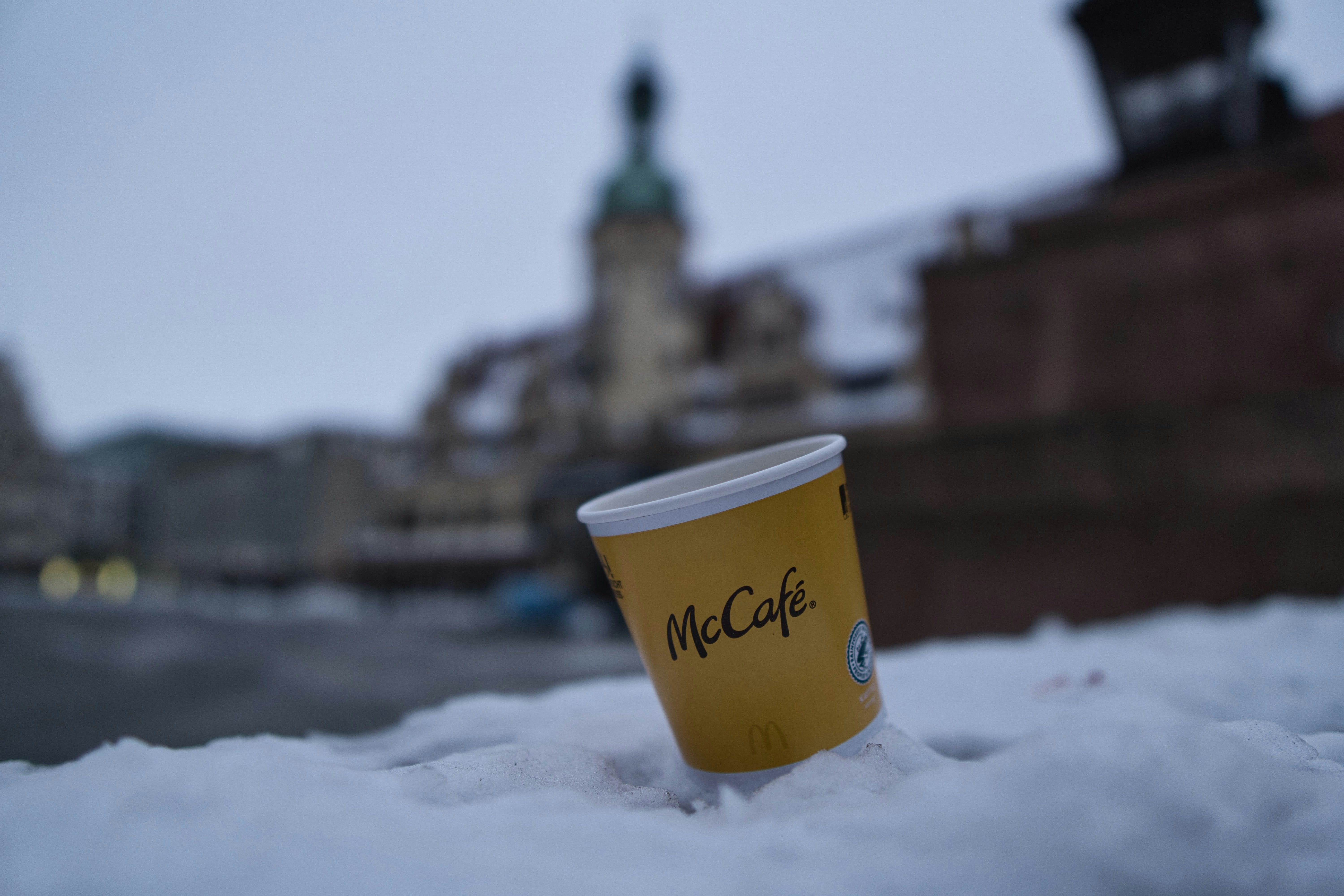 Snowy Sidewalk Café: A McCafé Cup in Focus