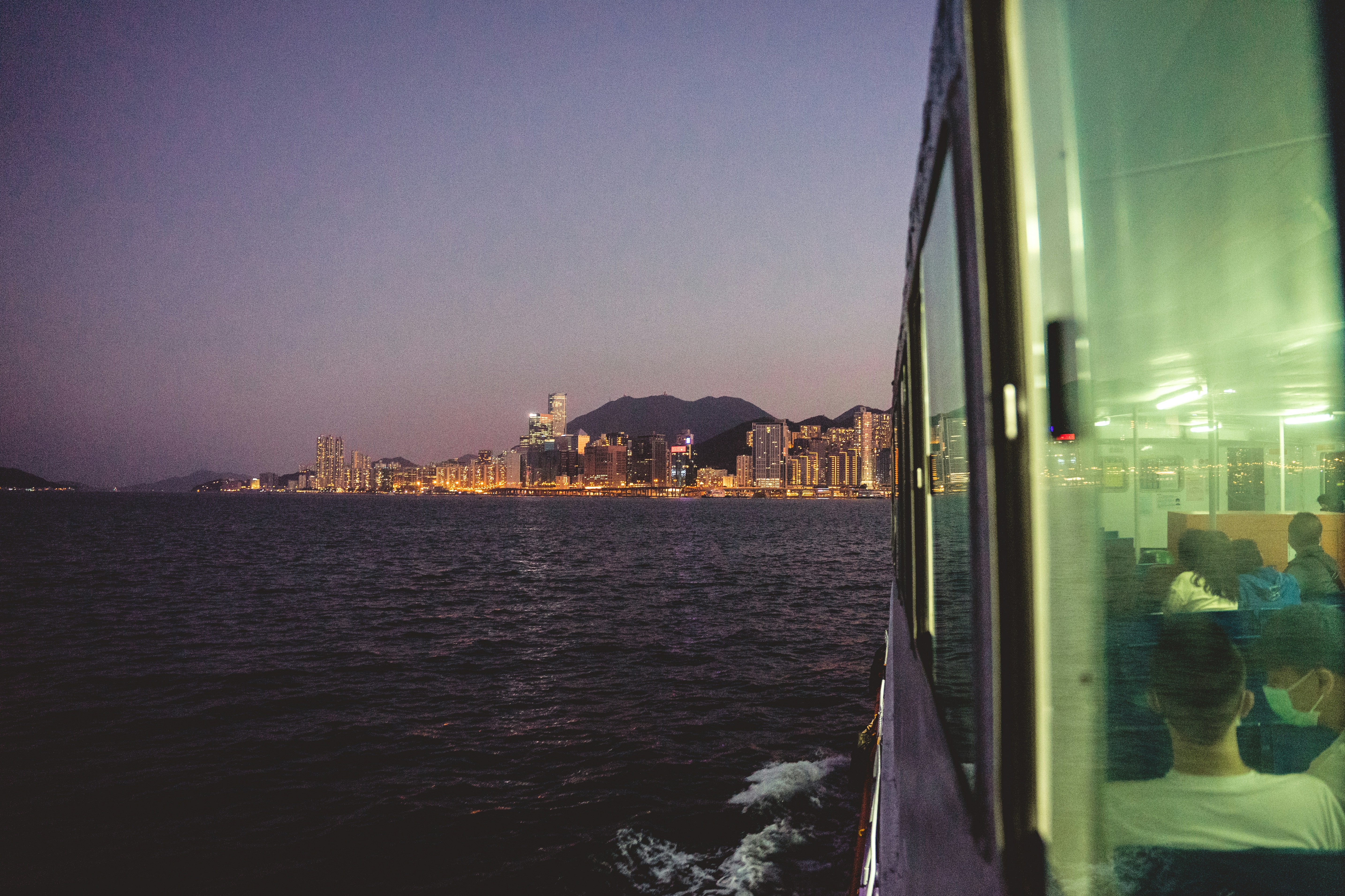 Harbor Lights at Dusk: Ferry Window View of a City Skyline