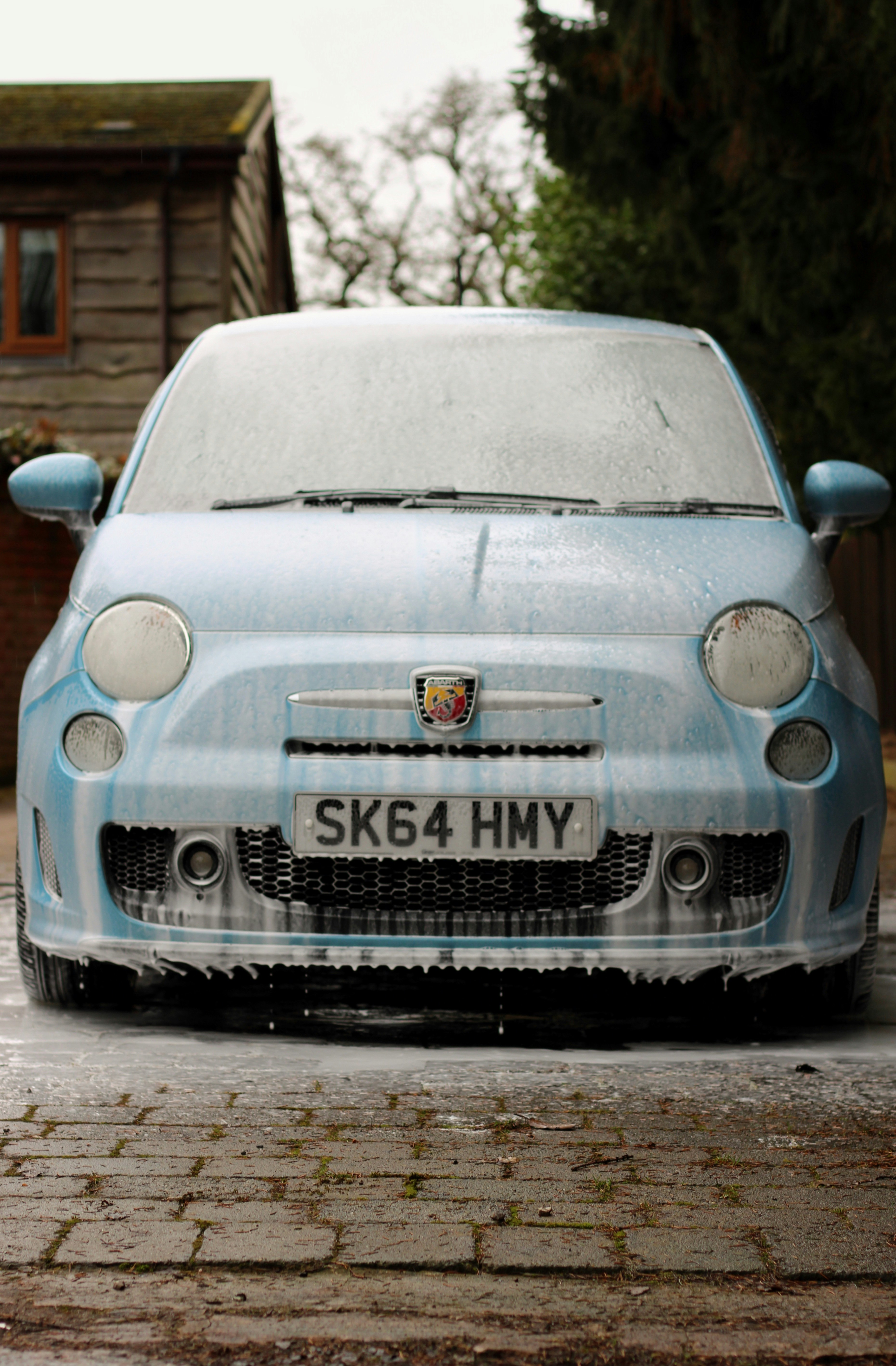 Frosted Blue Abarth: Front-View Portrait on a Cobblestone Drive