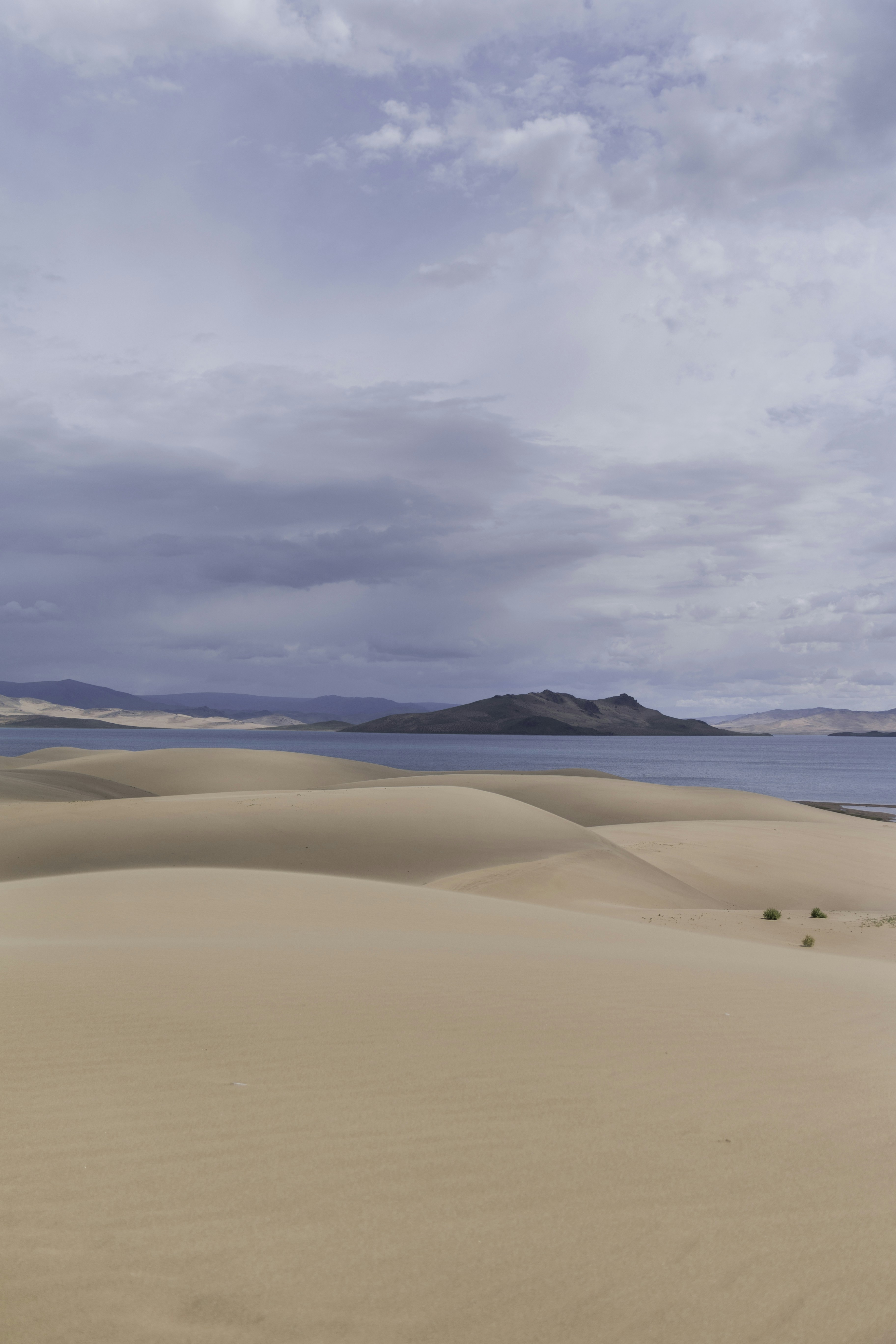 Echoes of Sand and Sea: A Clouded Horizon Over Desert Lake