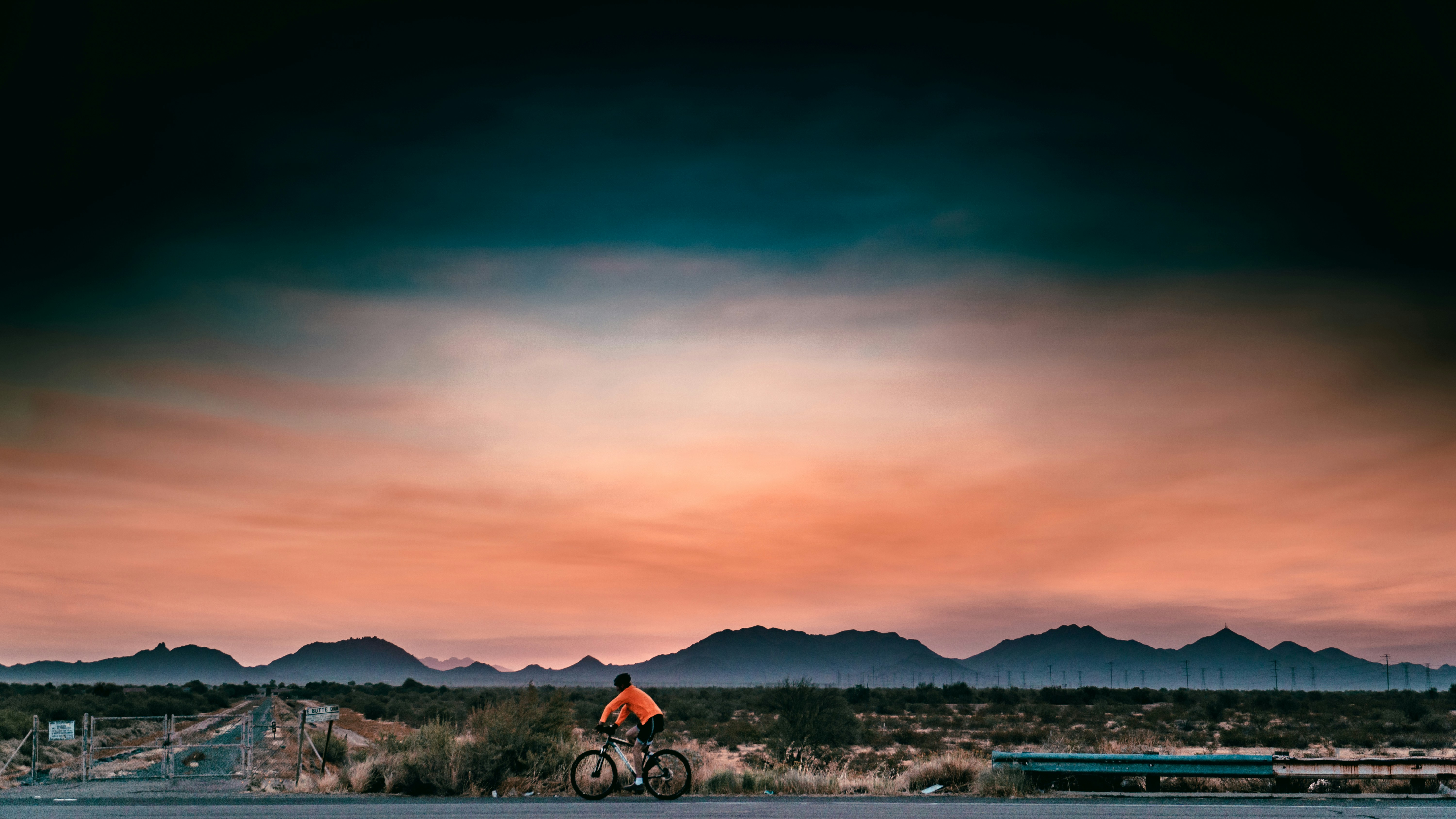 Desert Rim cyclist at dusk under pastel skies