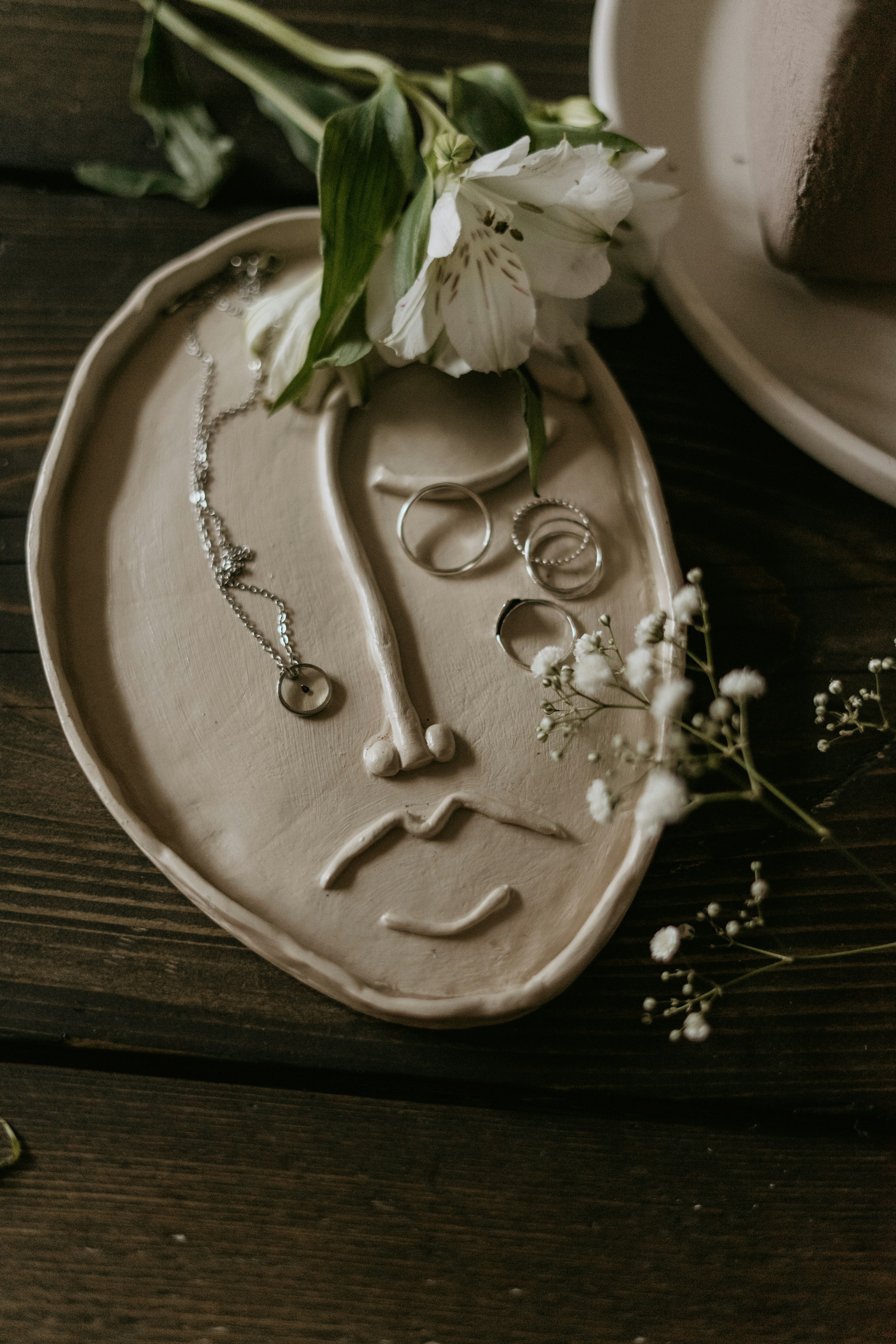 Face-Plate Still Life: Rings, Necklace, and a White Bloom