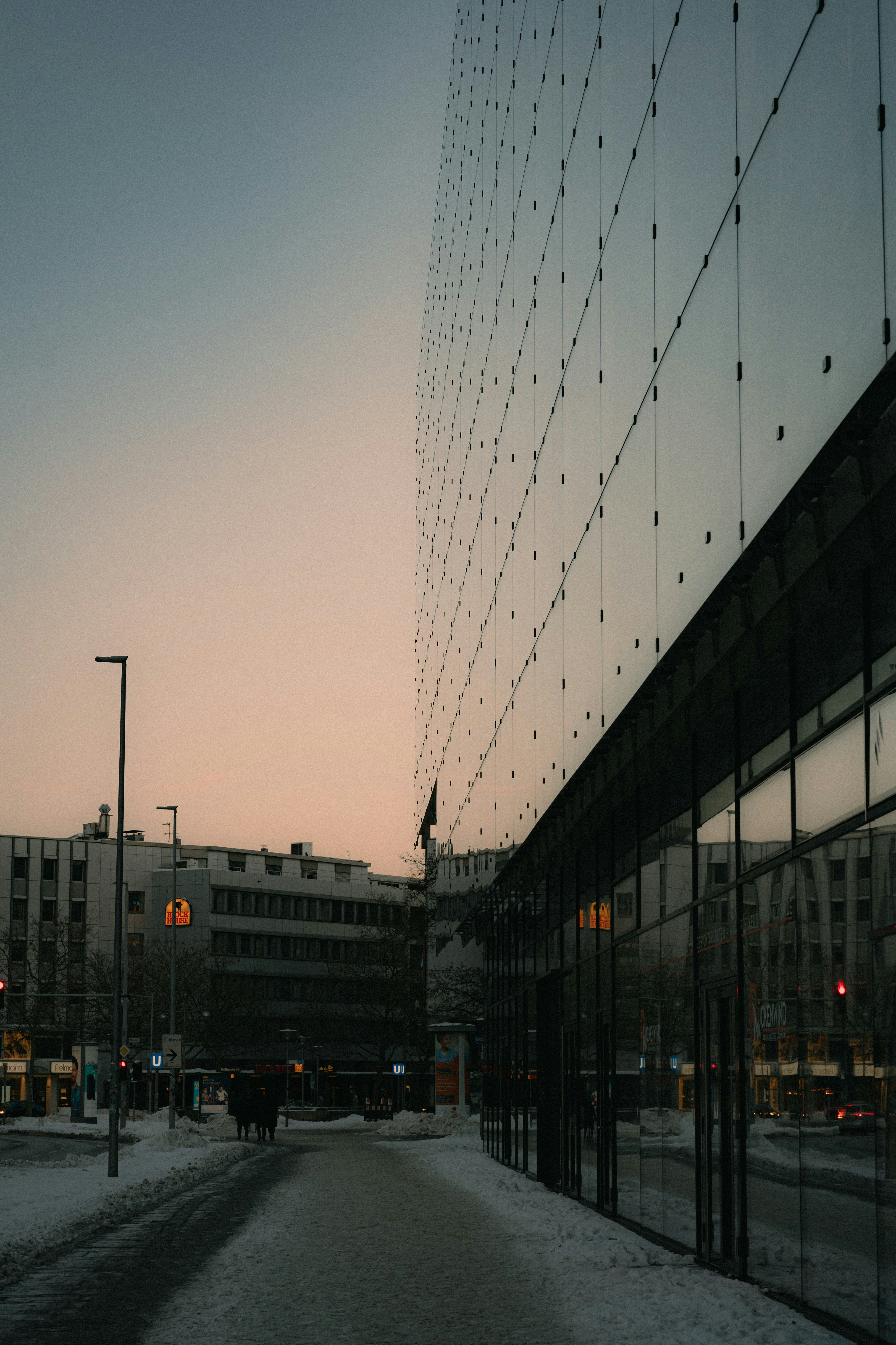 Sunset Convergence: Snowy Street Framed by a Glass Facade