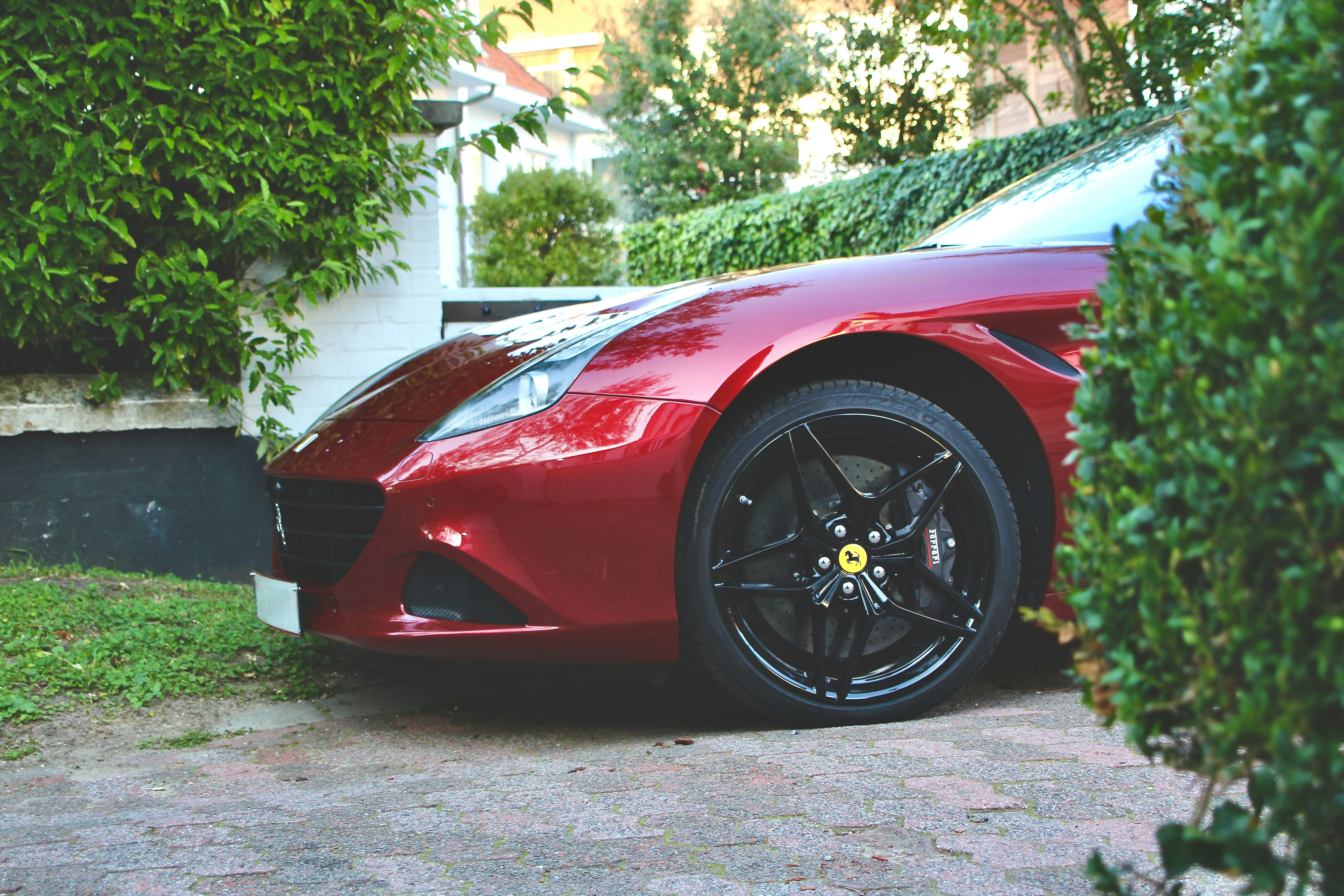 red ferrari 458 italia parked near white building