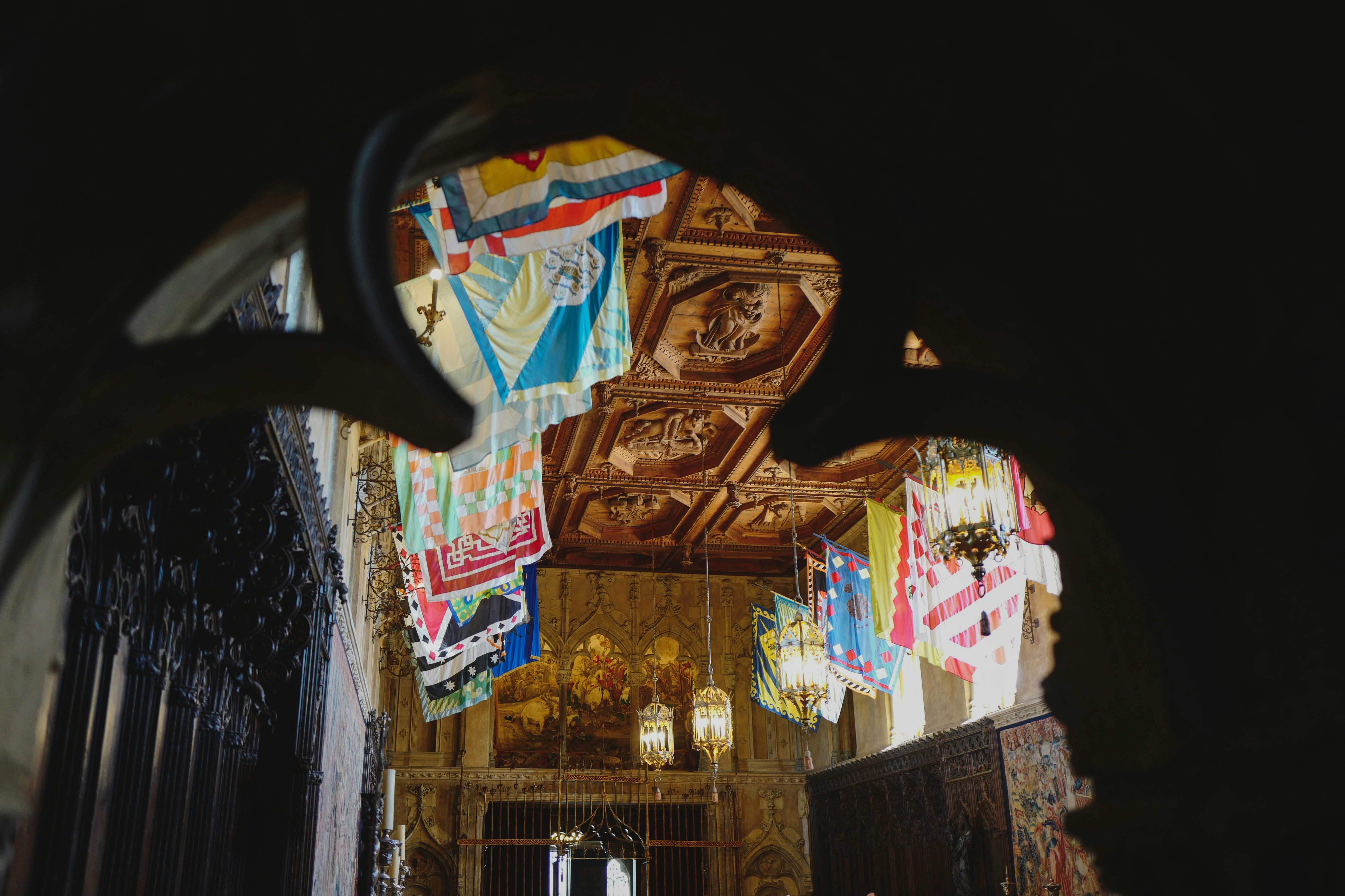 Through the Arch to Quiet Light: Altar Framed by Colorful Banners