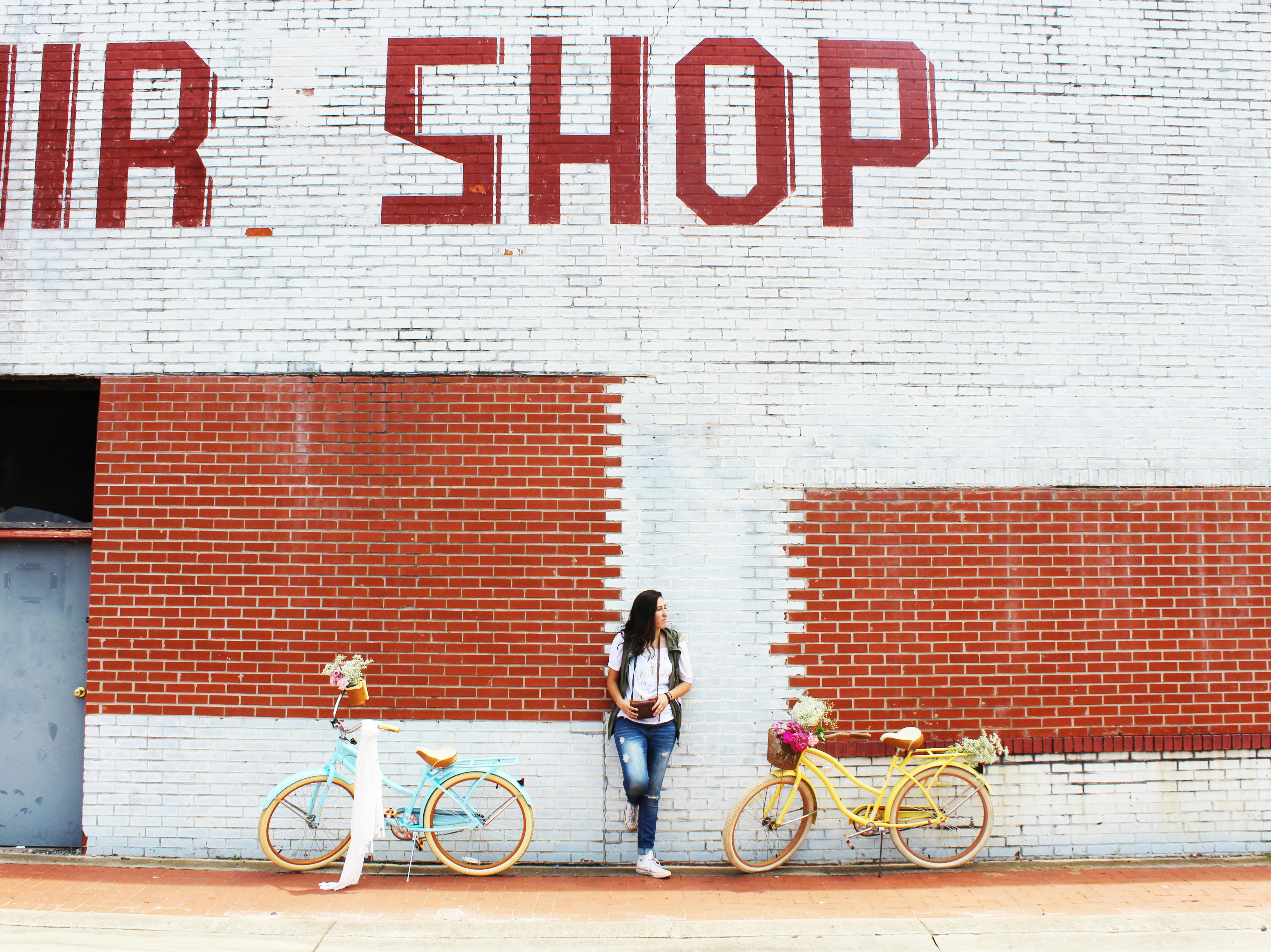 woman in blue denim jacket and blue denim jeans riding bicycle