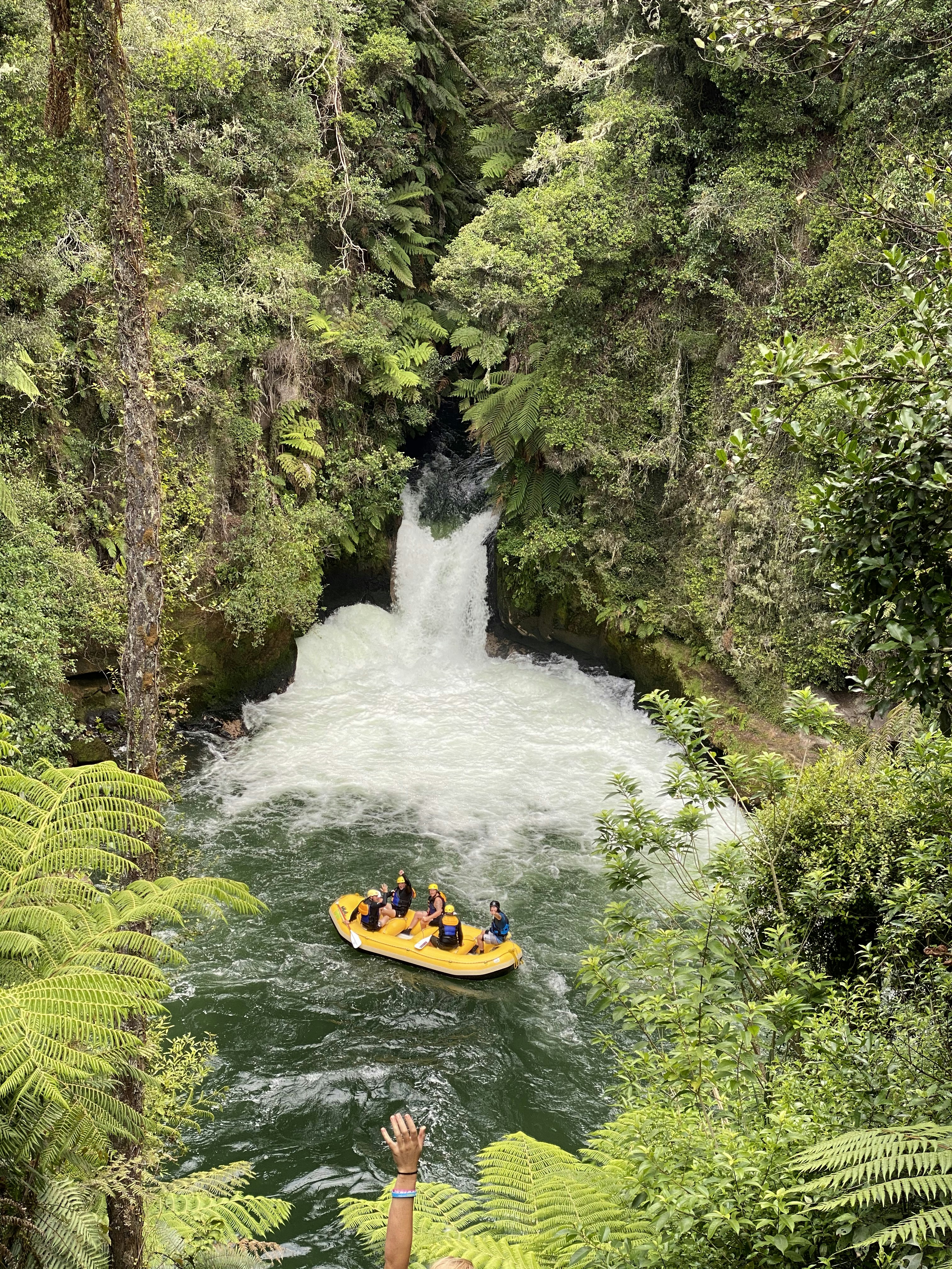 Rafting team maneuvers through lush greenery and rushing waters, showcasing the thrill of adventure in nature's embrace.