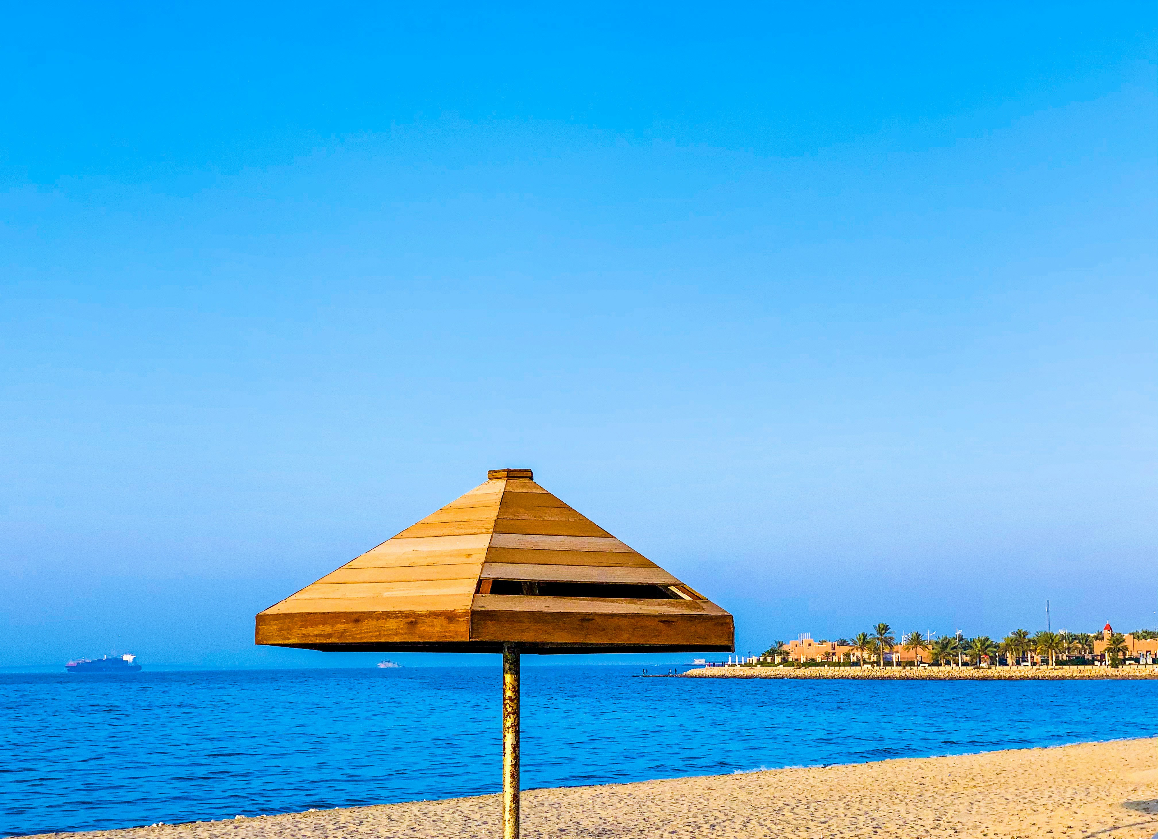 Brown wooden beach lounge chair on white sand beach during daytime ...