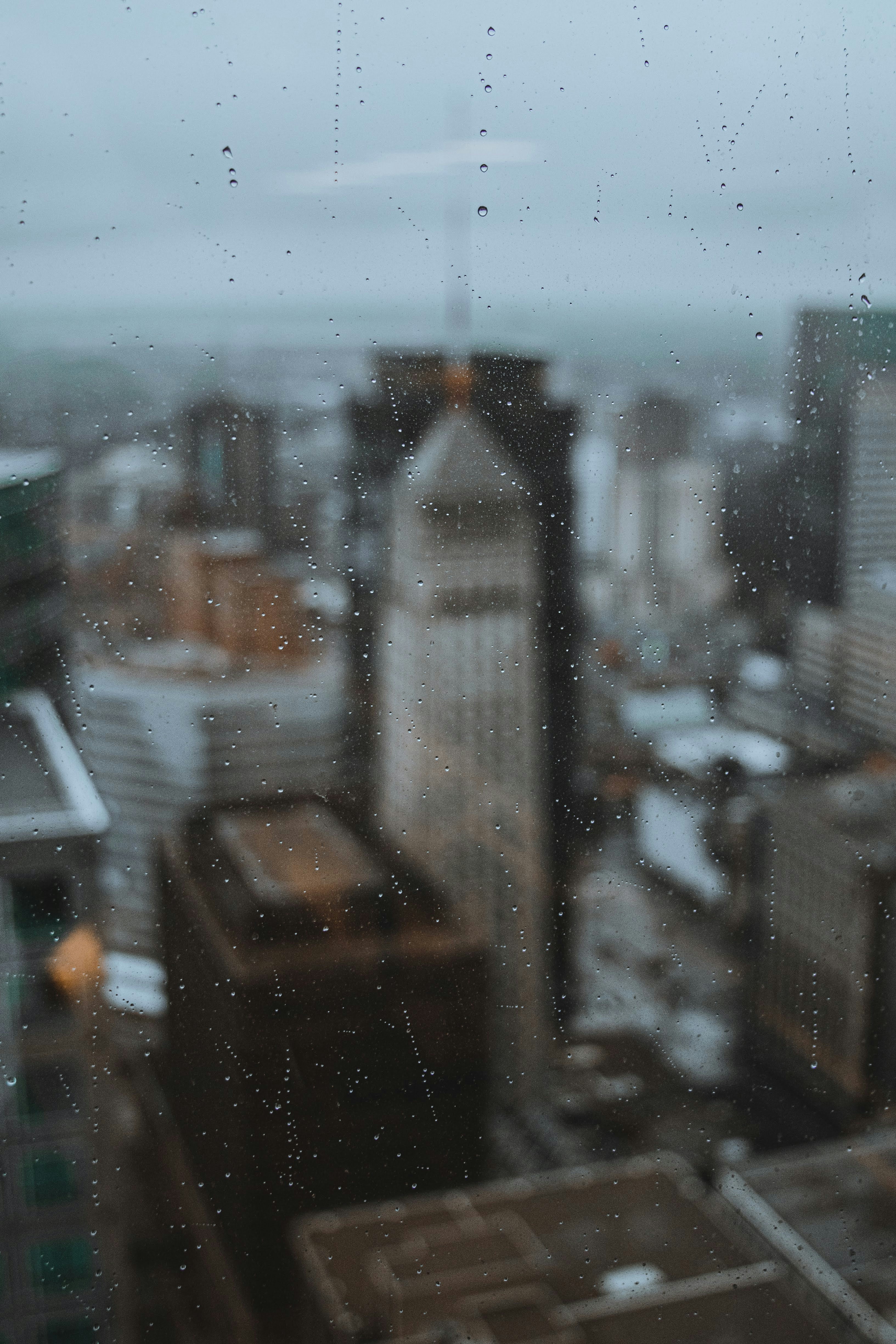Rain falling down window with city in background @nalty_photography on Instagram | white van parked on the side of the road