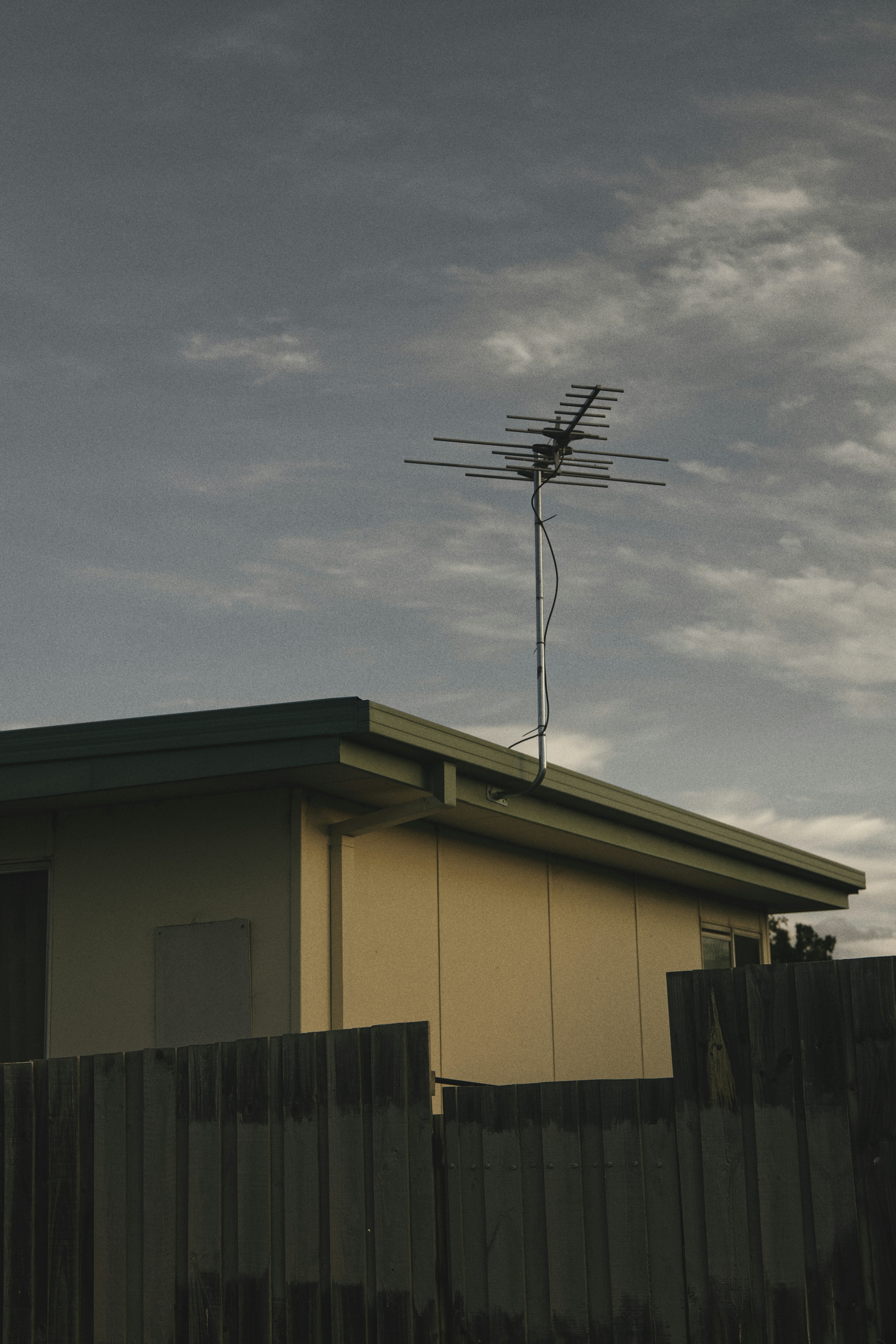 Antenna Against A Sunset Sky Over a Quiet Rooftop