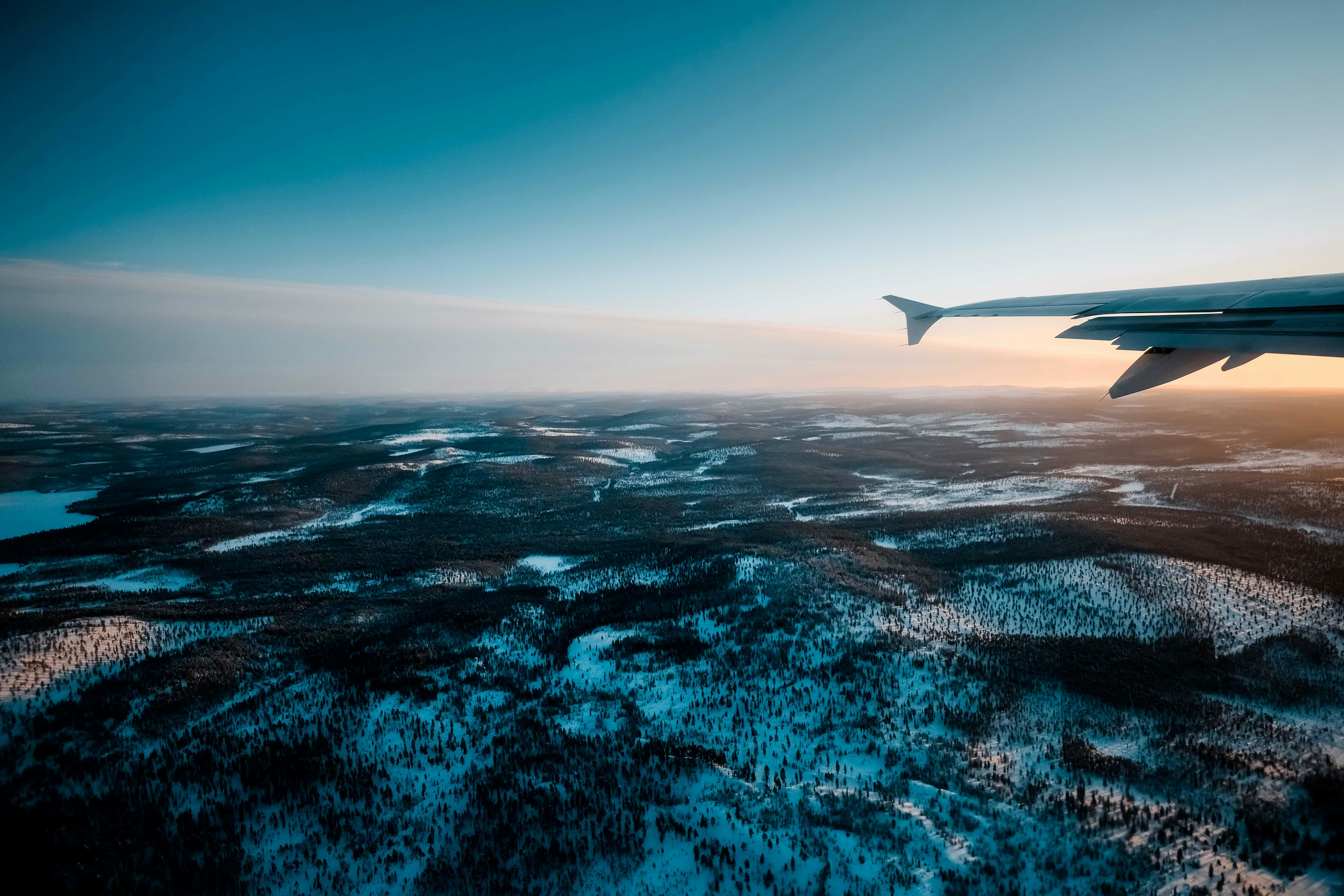 Wingtip Reverie: Snow-Blanketed Plains Glide Under Sunset