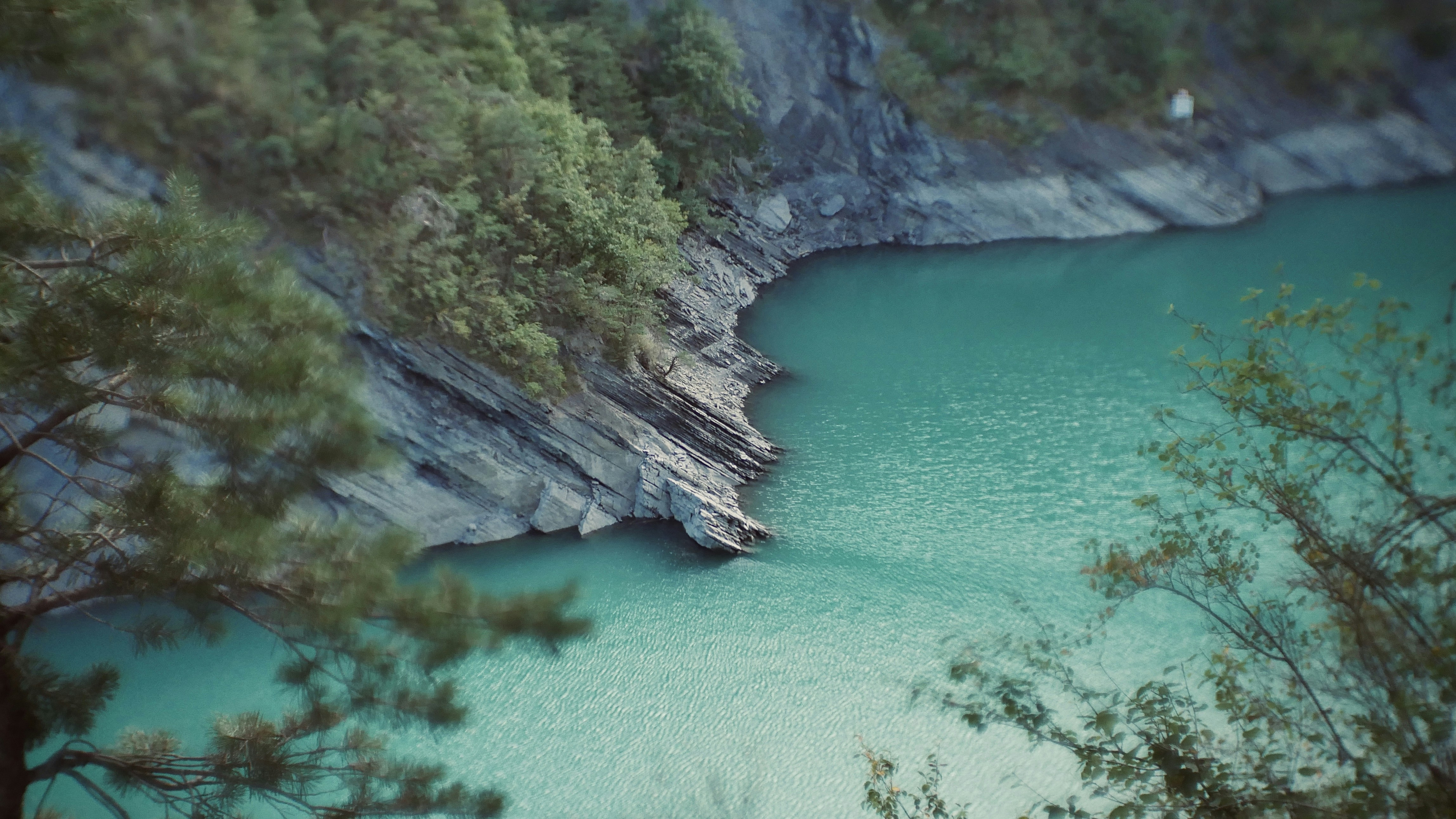 Turquoise waters lap against rugged cliffs, framed by lush greenery.