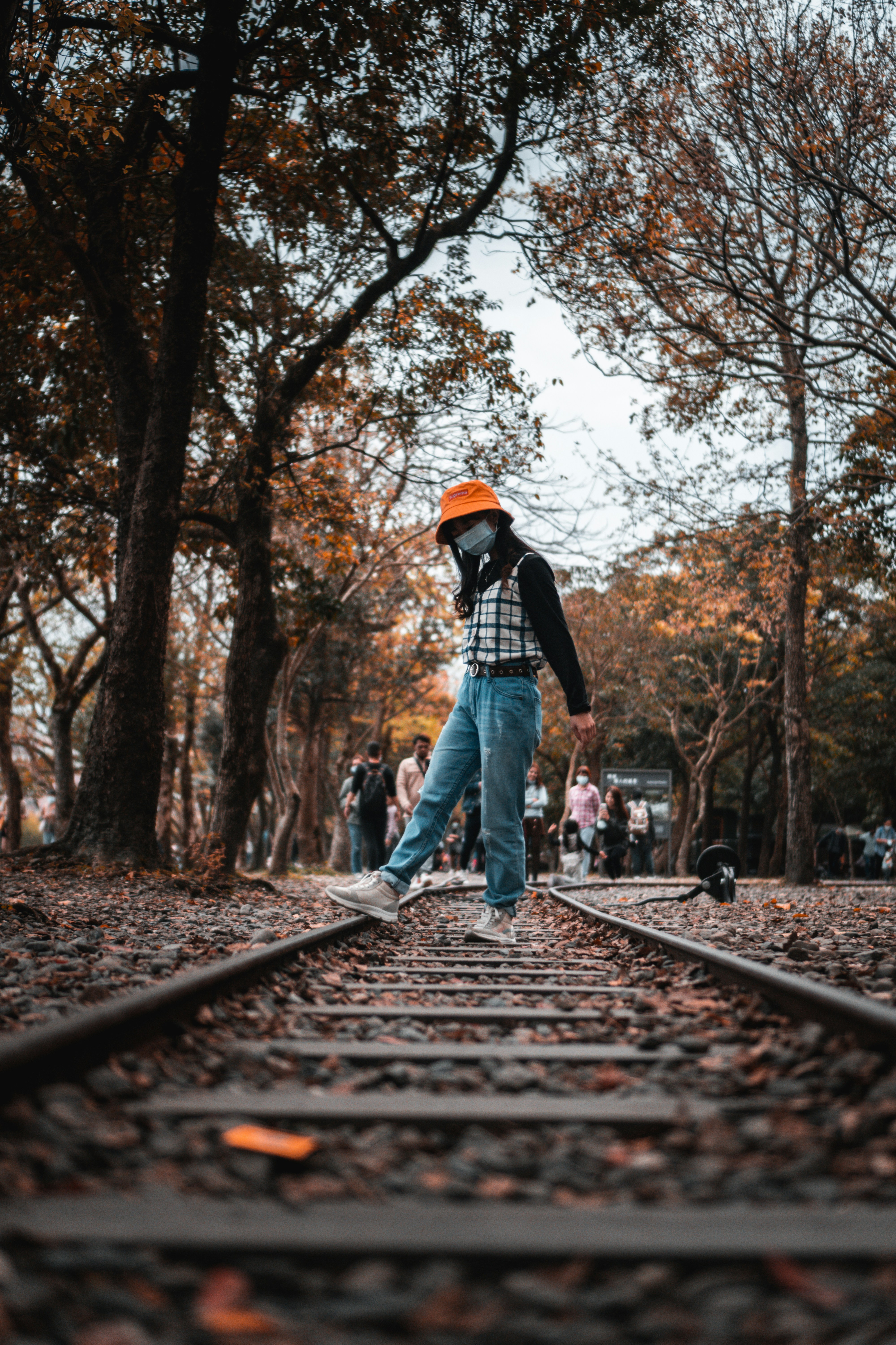 Man in black jacket and blue denim jeans standing on train rail during ...