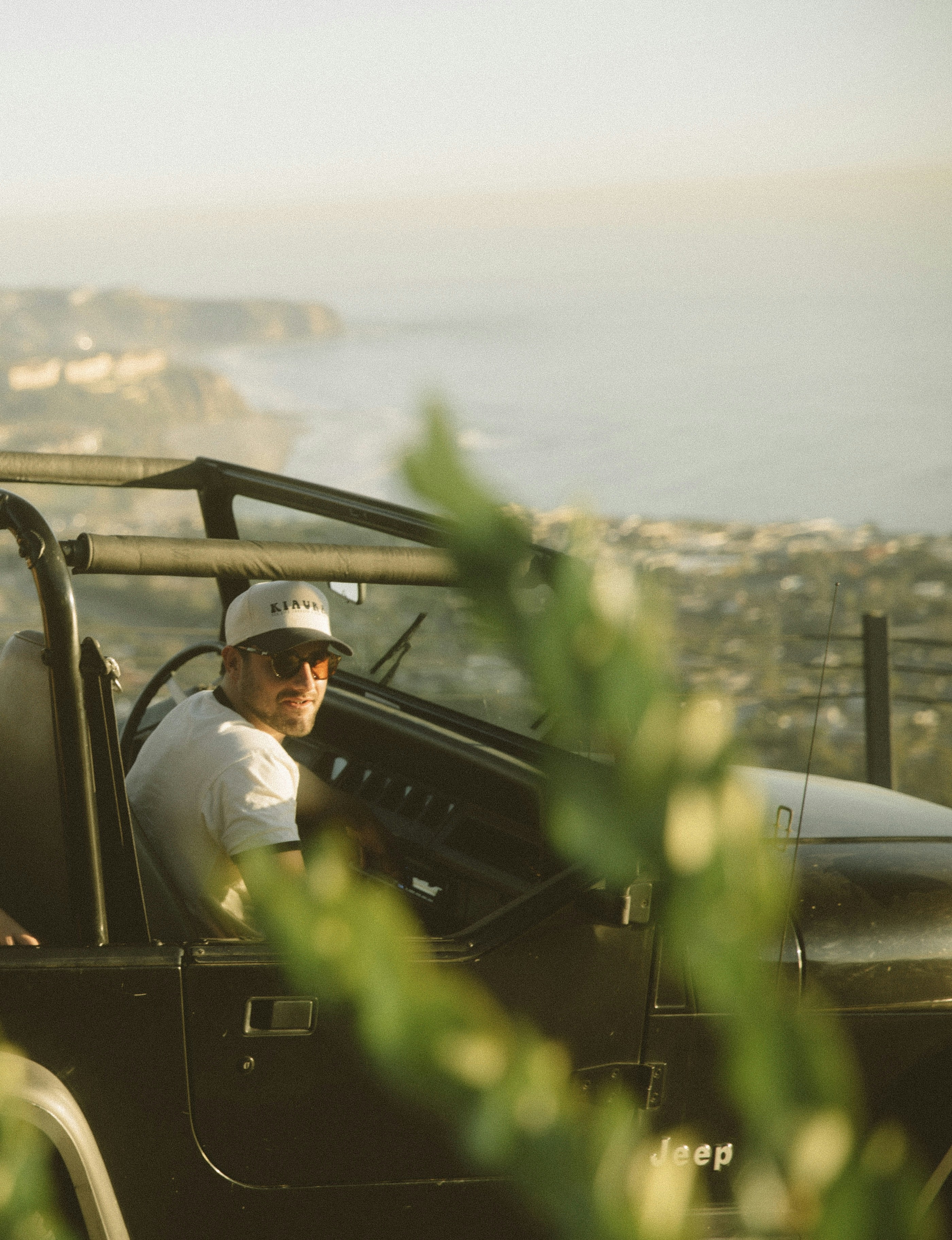 Sunlit Jeep Driver: Quiet Gaze Through a Sea of Green