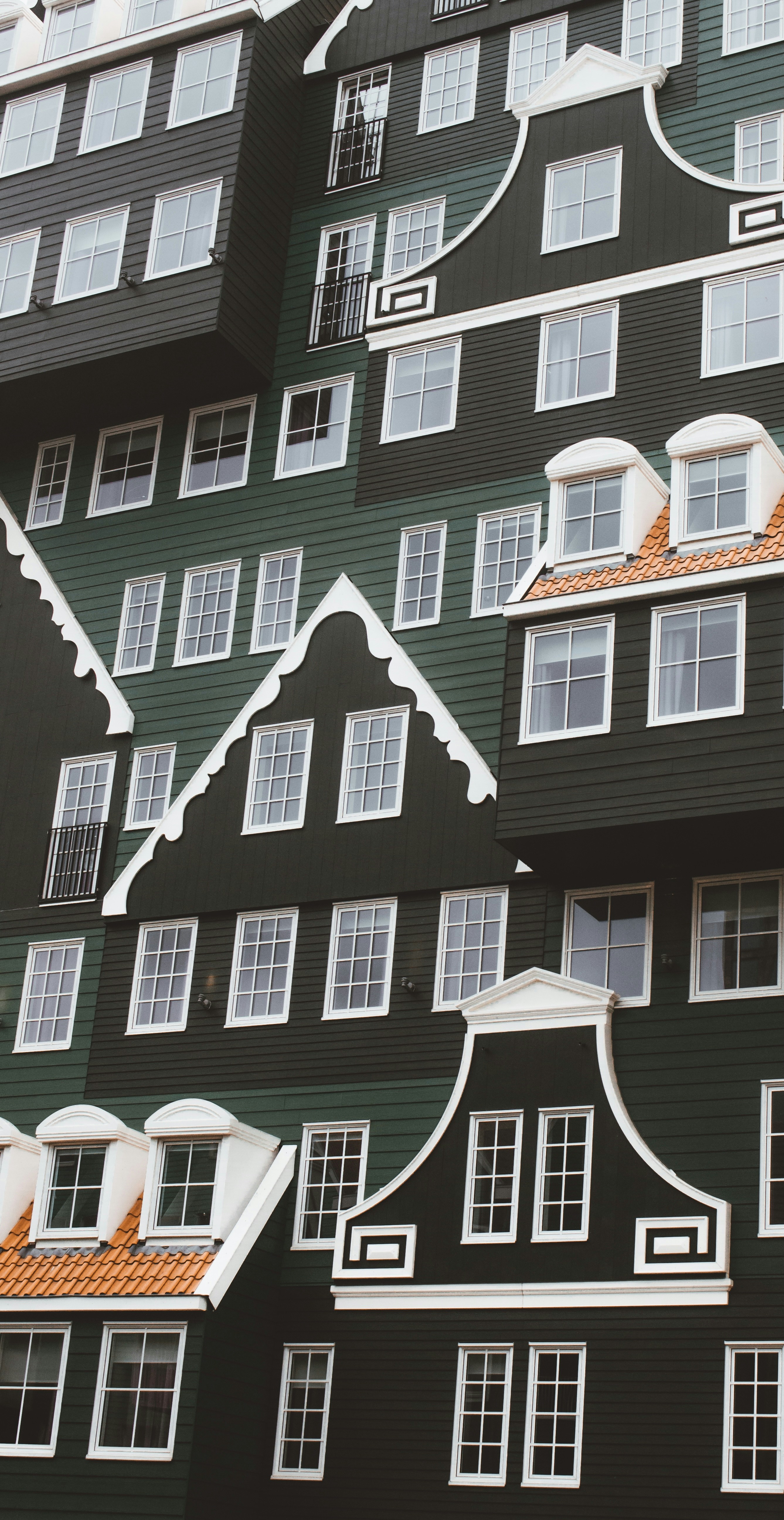 Facade Mosaic: Stepped Gables and White Trim on a Green-Black Building