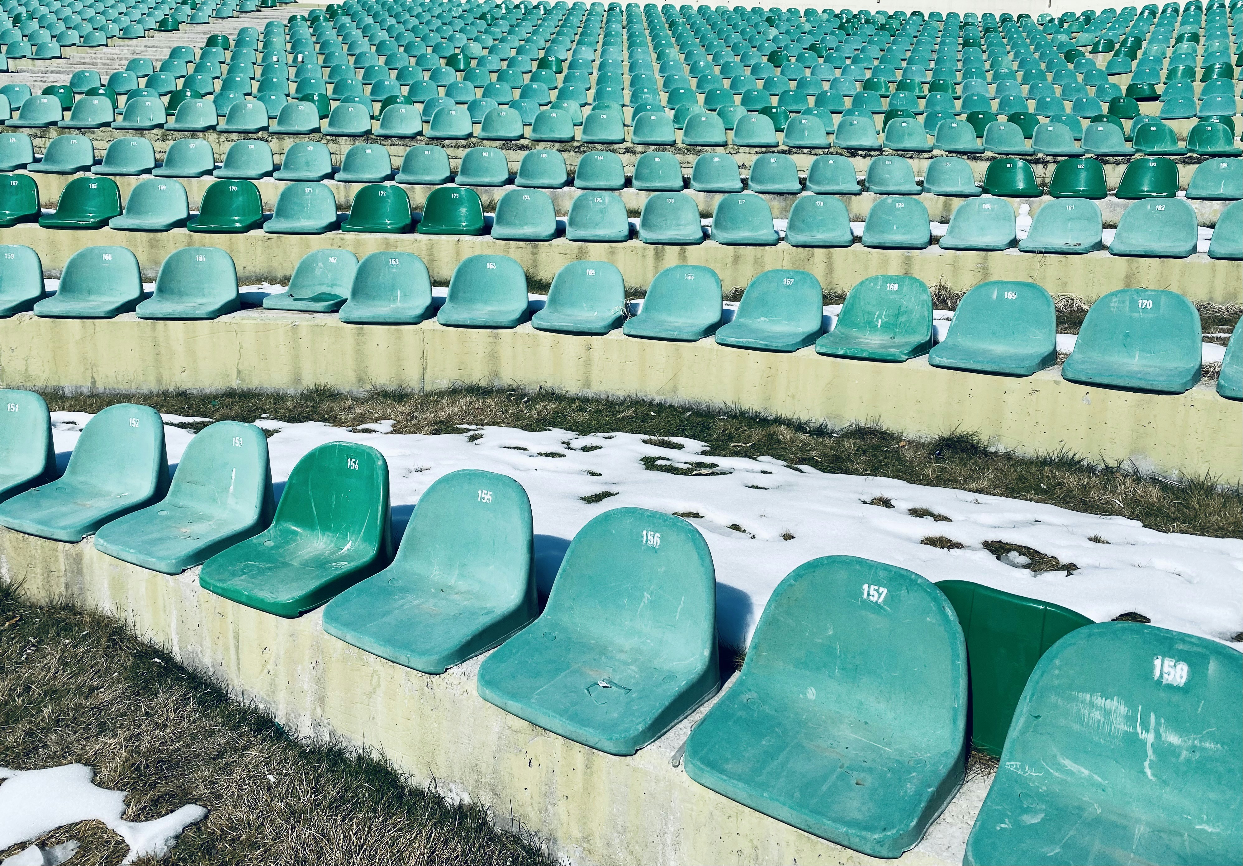 Rows of Weathered Teal Seats Under a Clear Sky