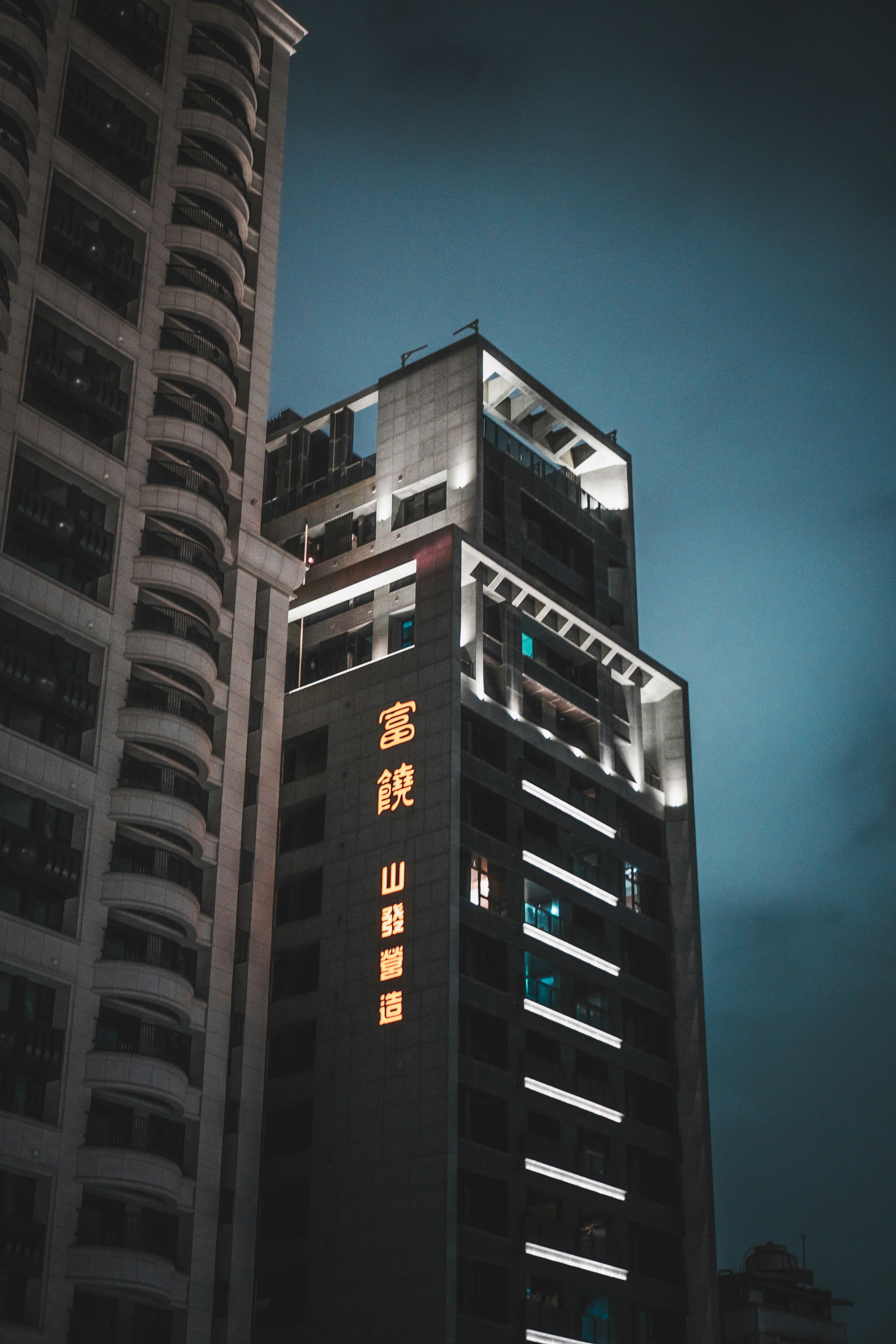 Illuminated skyscraper showcasing sleek lines and modern design against a twilight sky.